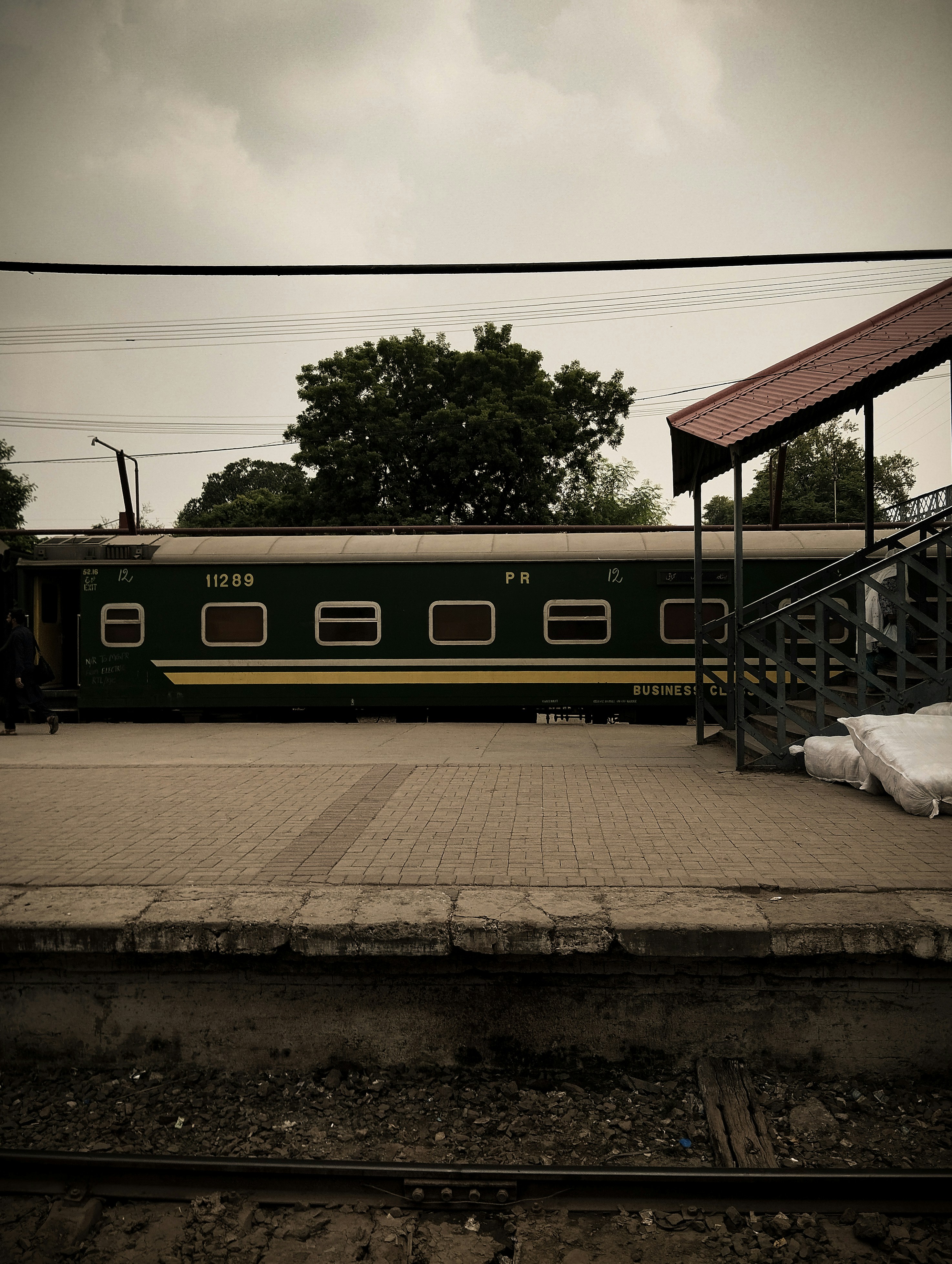 Green train car at a station platform