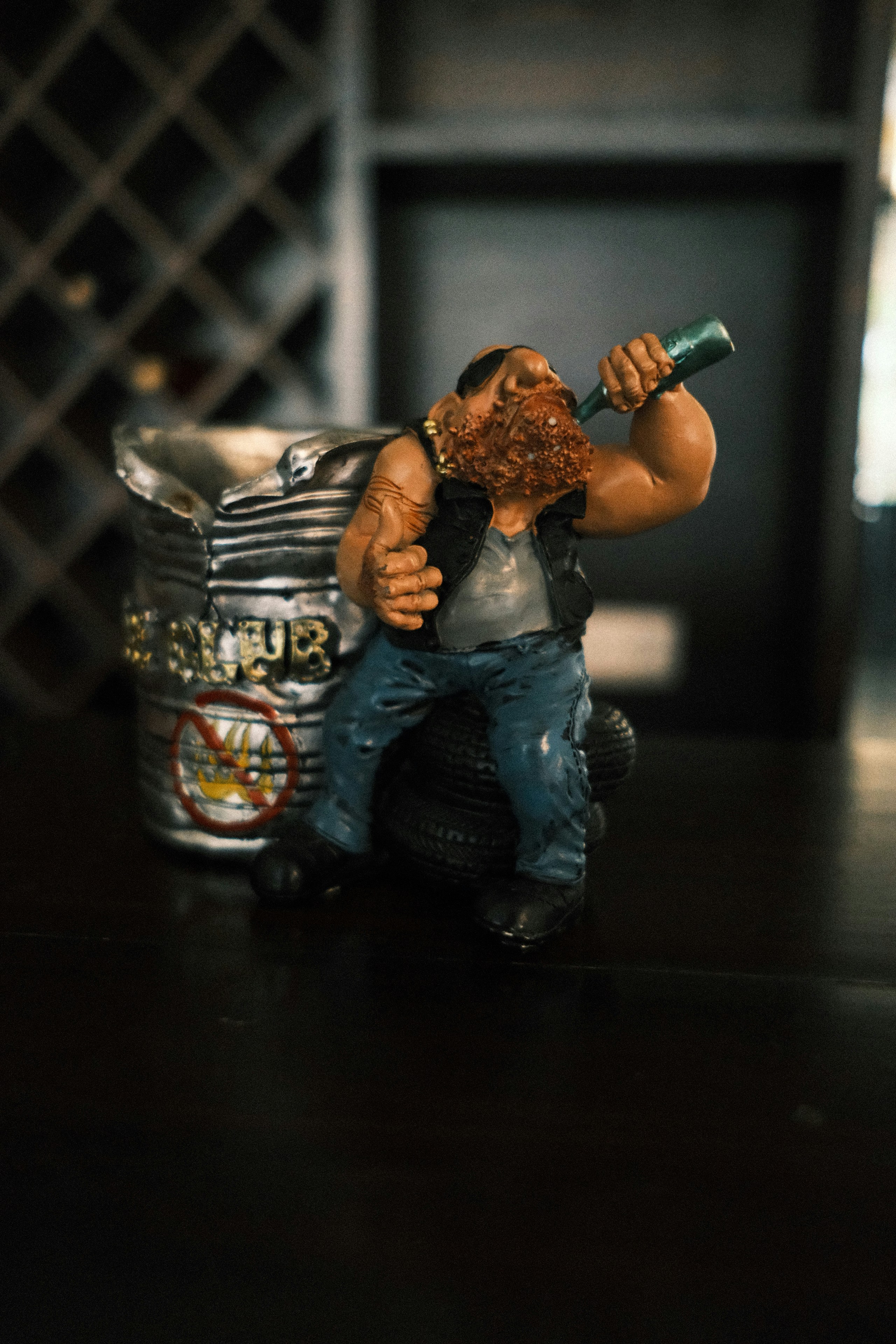 Mini Brawler, Big Ambition: A Figurine with a Beer-Can Backdrop