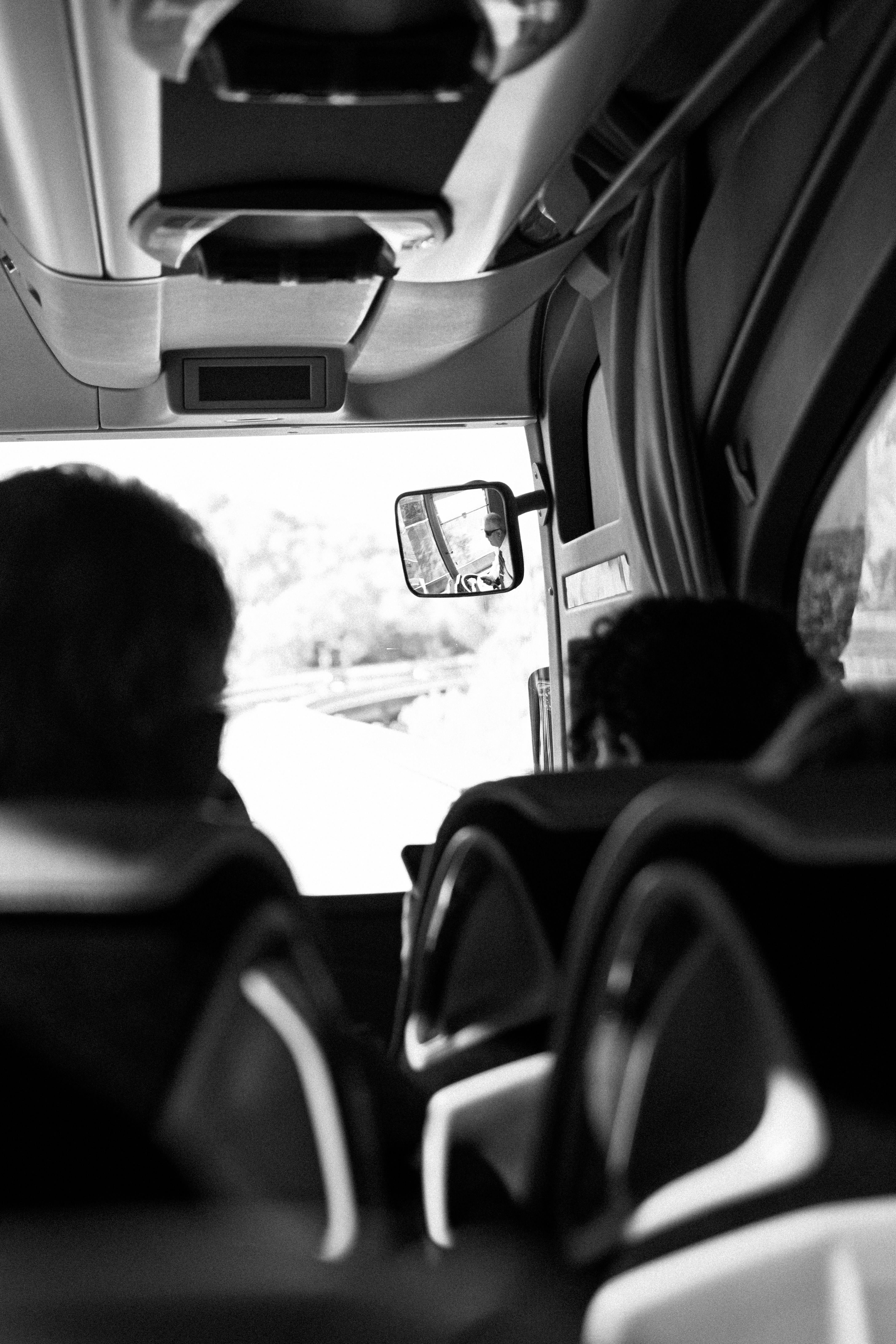 Rear-Seat Perspective: The Bus Window Mirror Reflects Quiet Motion