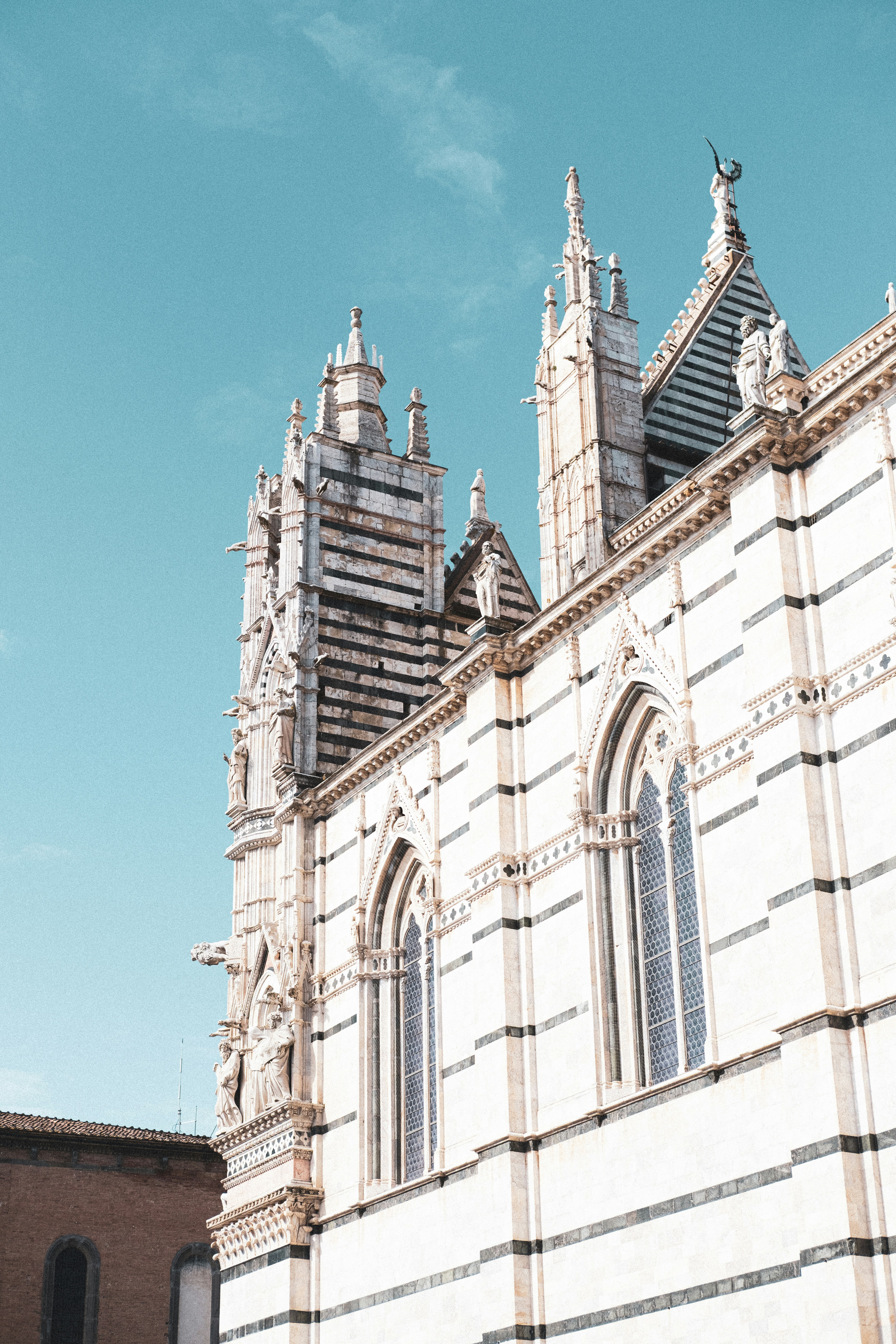 Stone Spire and Arched Windows: A Sunlit Facade