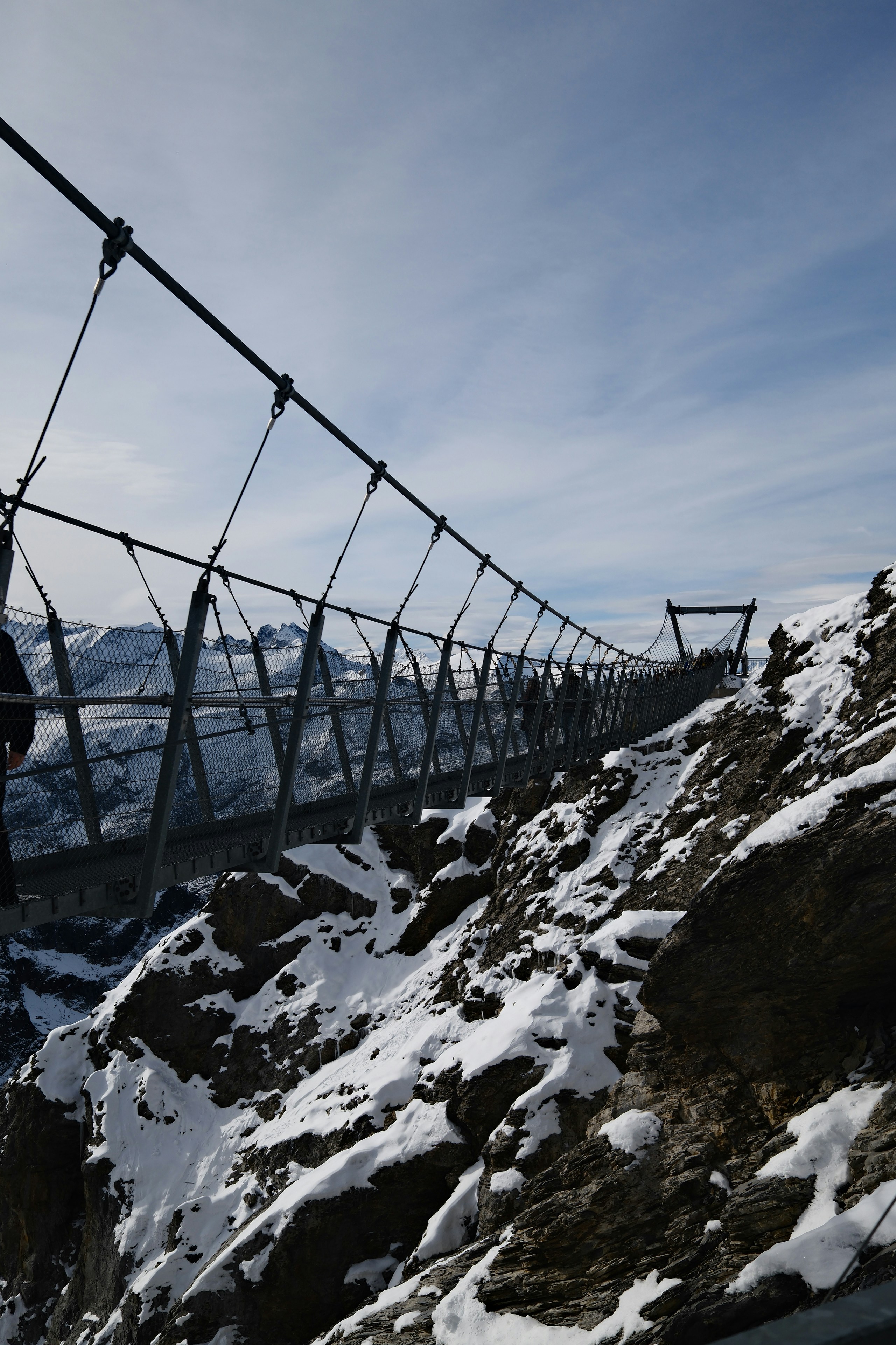 Snowy Skywalk: A Narrow Bridge Clinging to the Mountain Edge