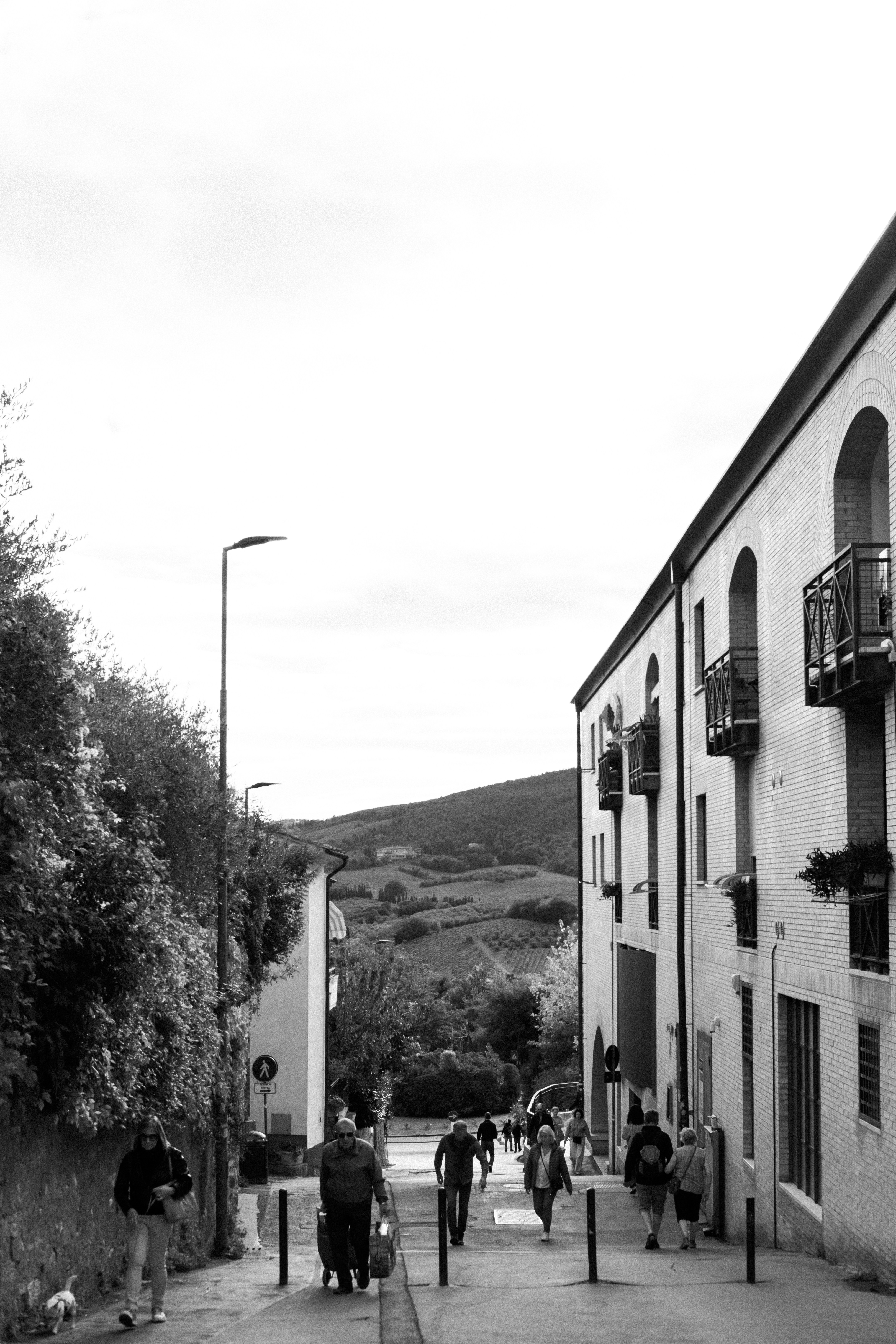 Quiet Downhill Street Between Brick Apartments