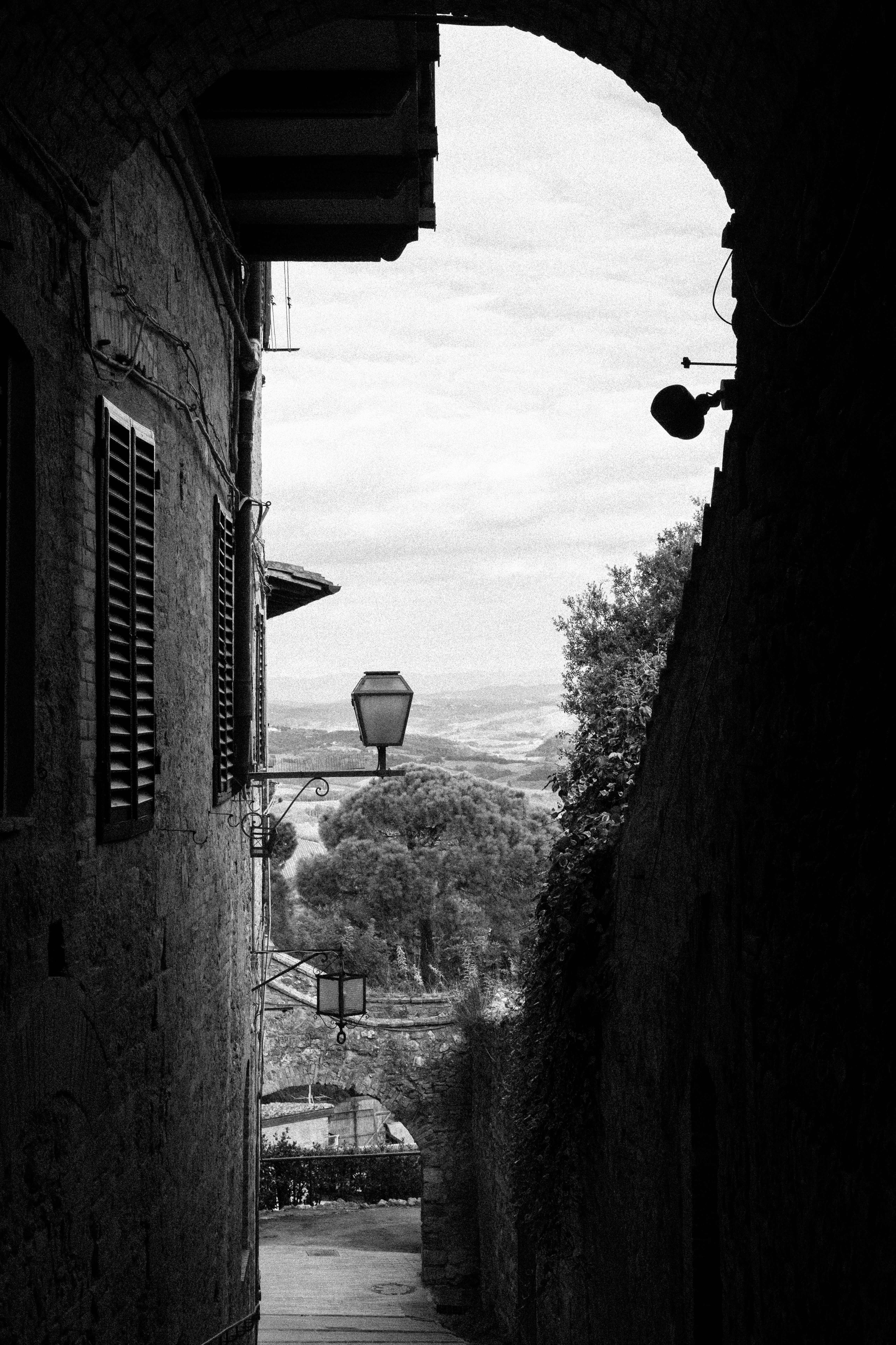 A Stone Corridor Framed by Shadowed Walls and Distant Hills