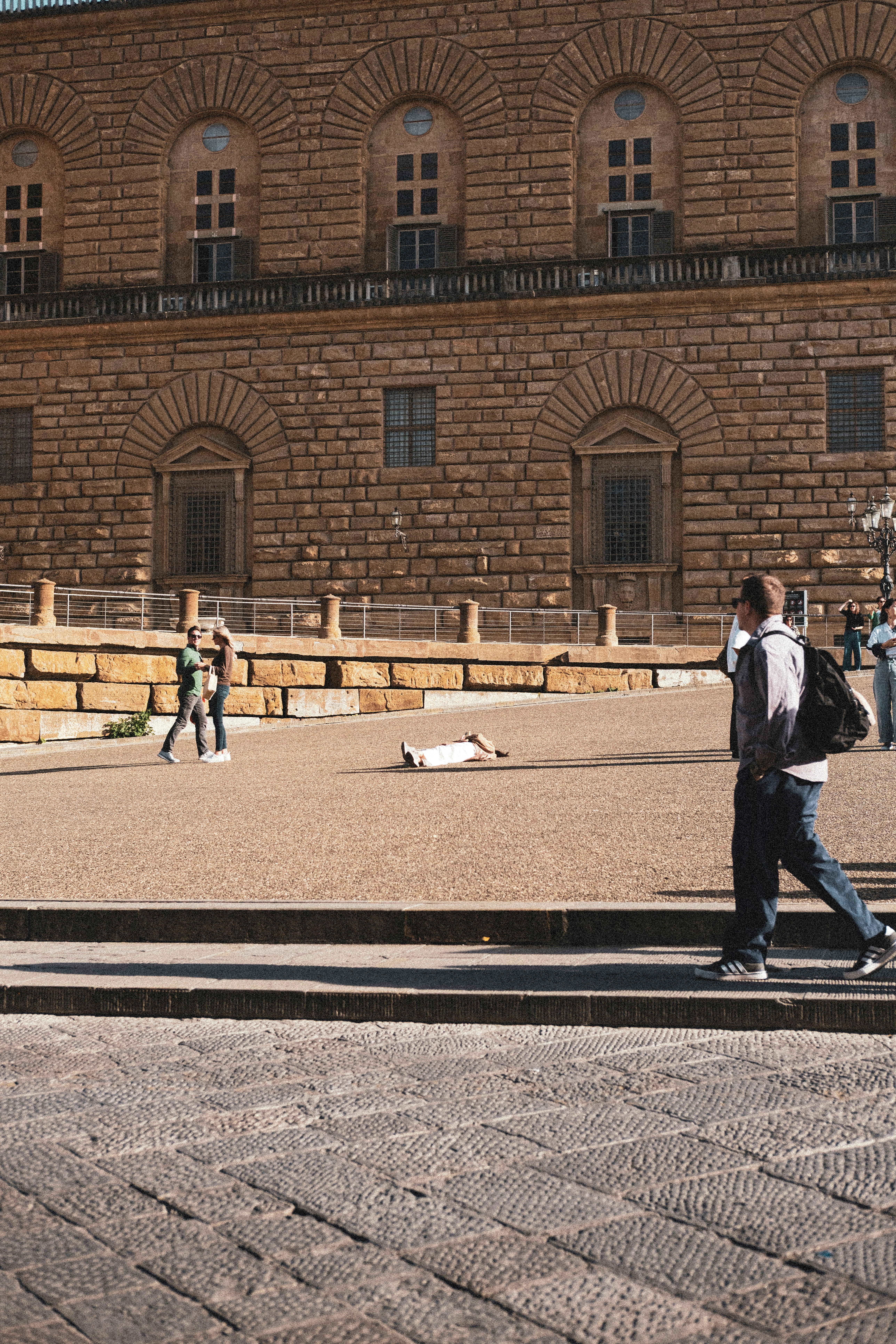 Street Scene by Historic Brick Facade with Pedestrian in Motion