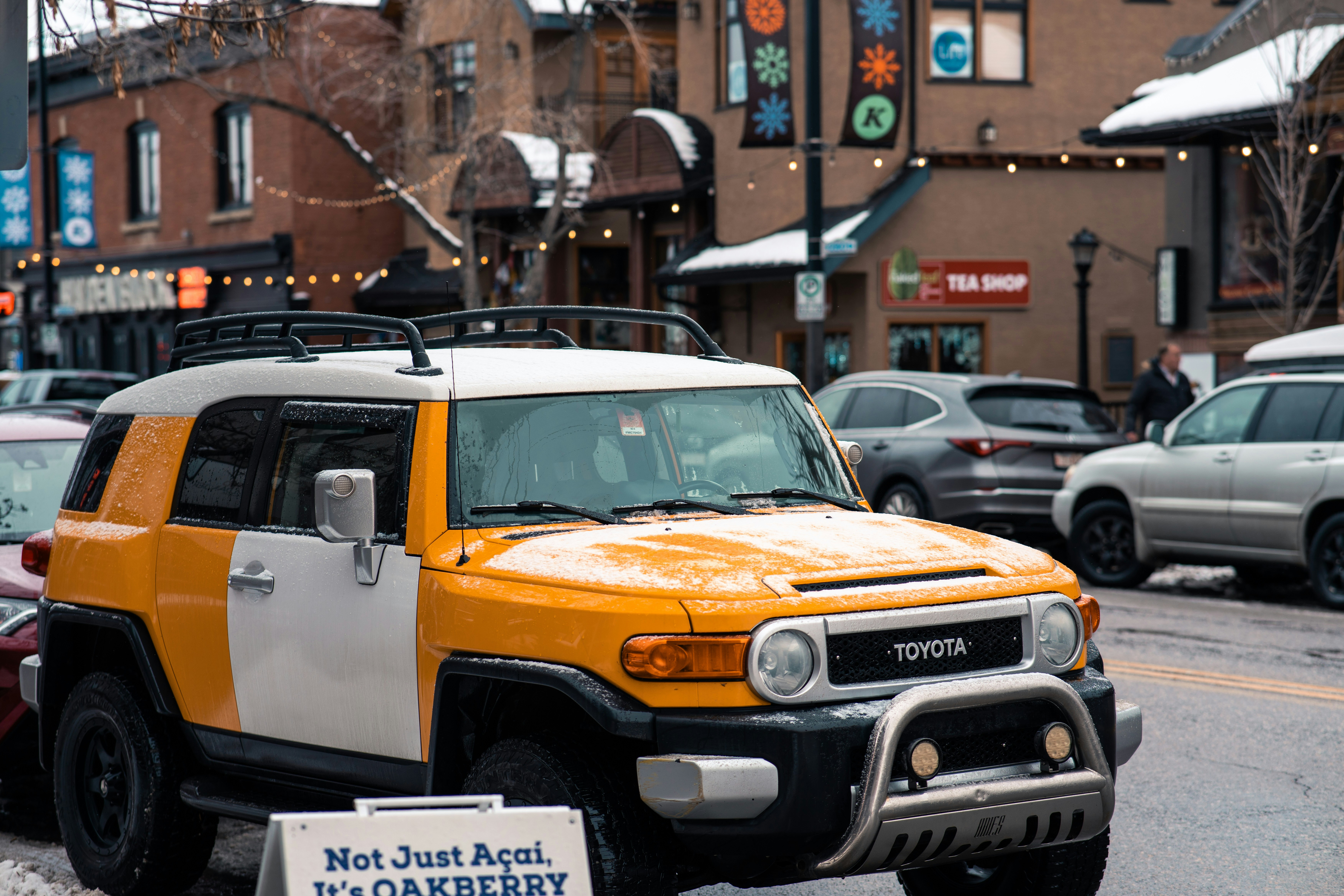Sunny Toyota on a Winter Street: A City Scene with a Bold Orange SUV