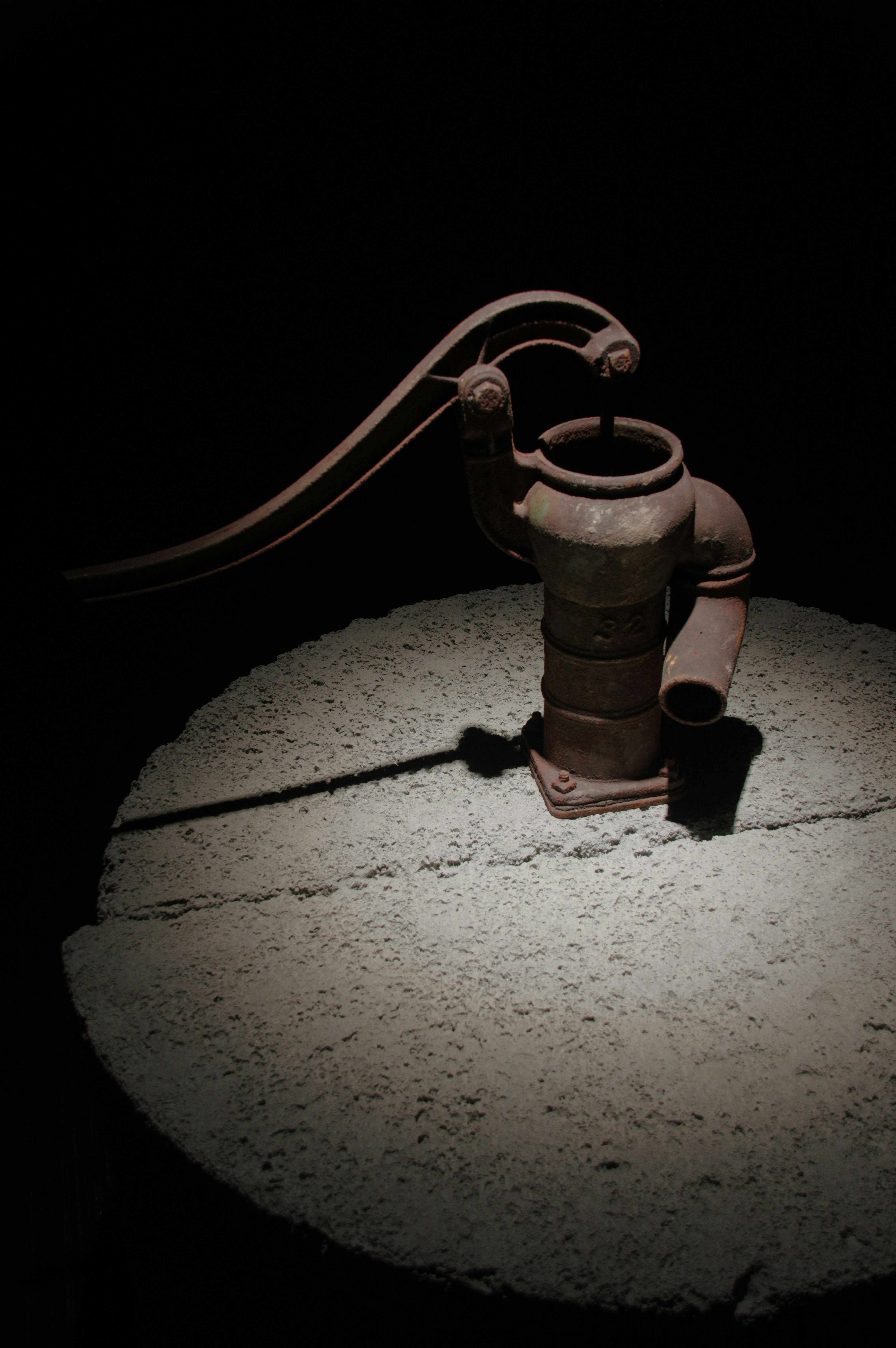 Old Well Pump Under a Spotlight: A Quiet, Dusty relic