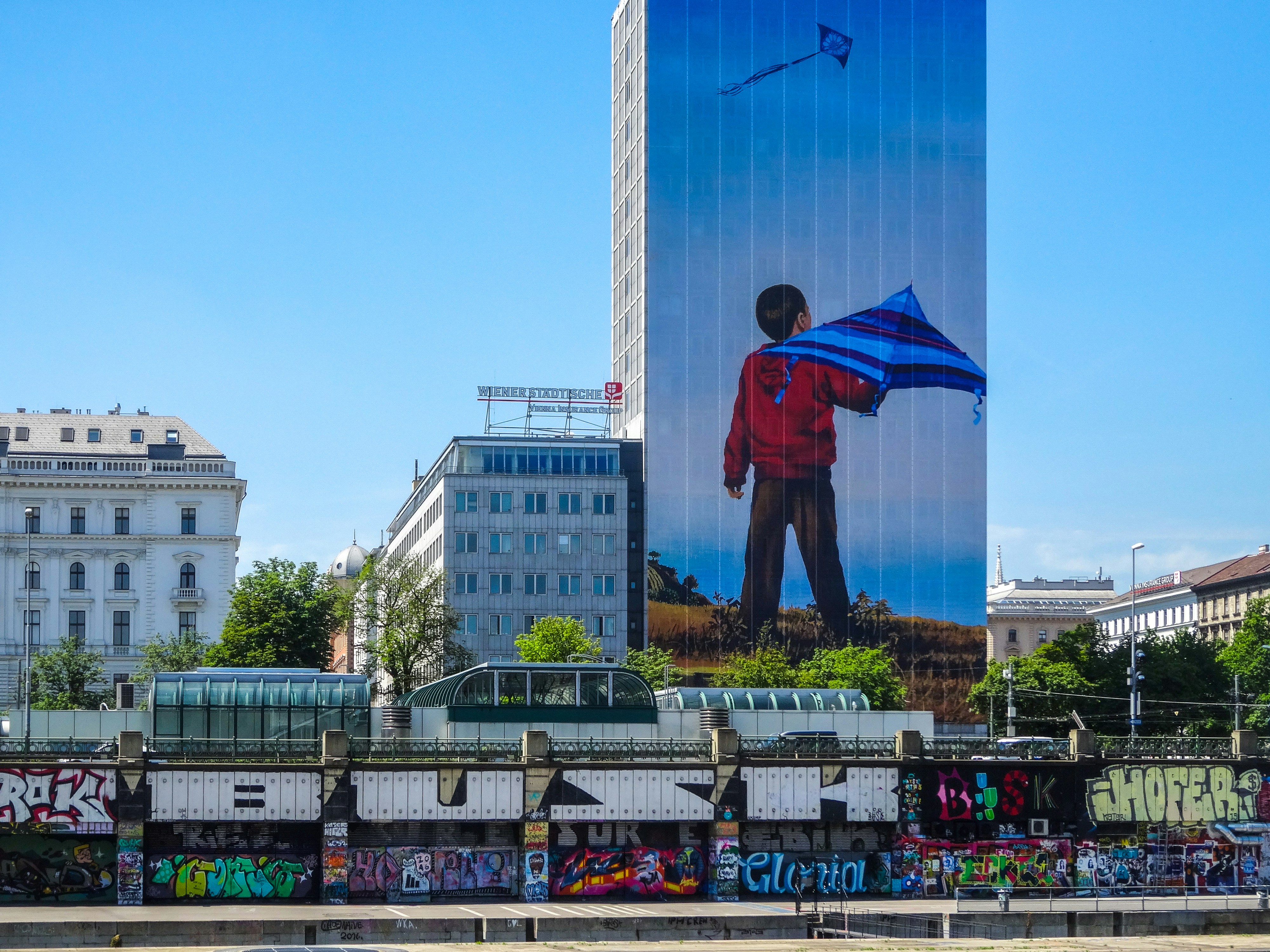 Reflected Promises: A Child with Blue Umbrella on a Glass Wall