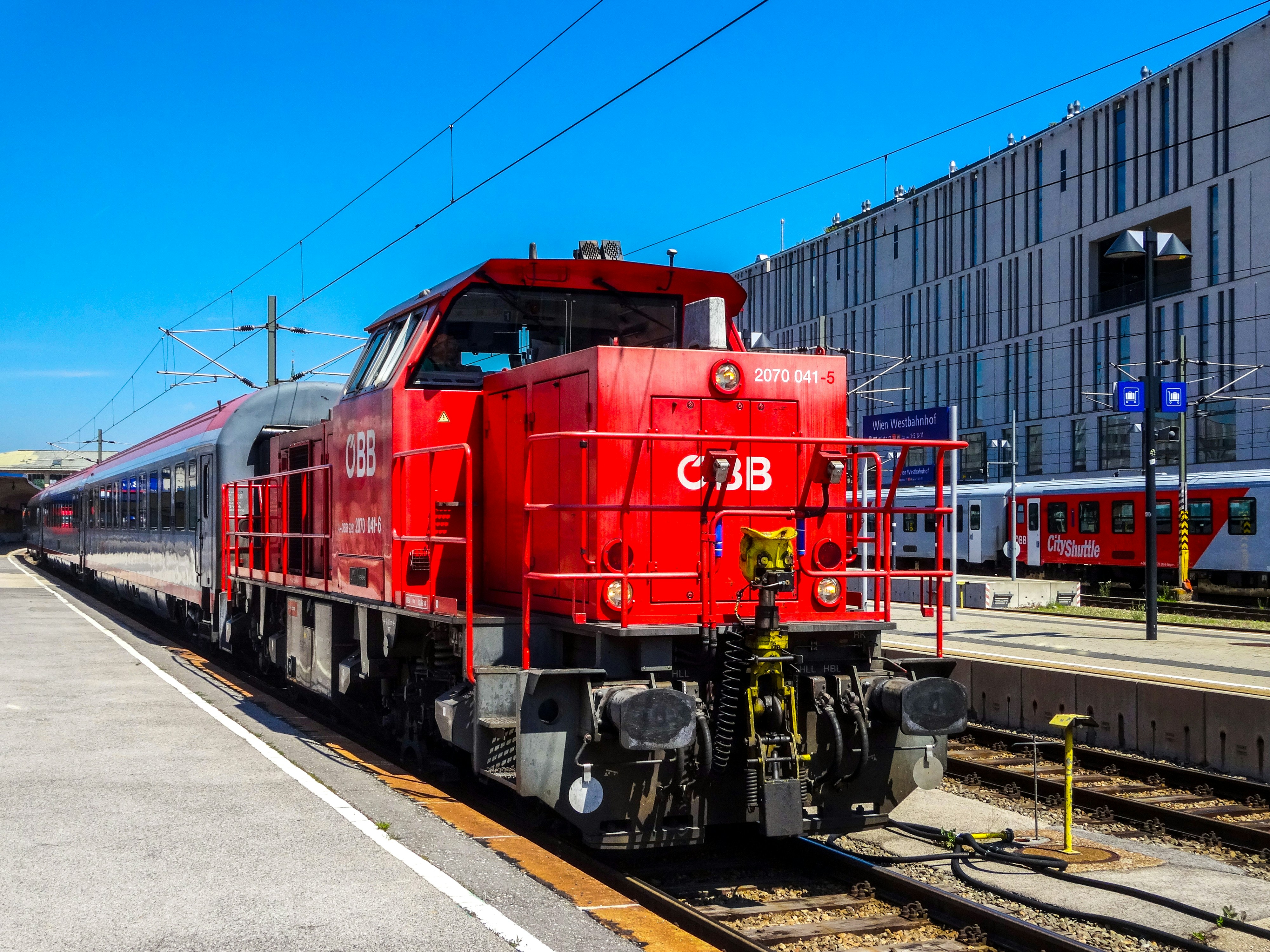 Red diesel beast at platform edge under cobalt sky
