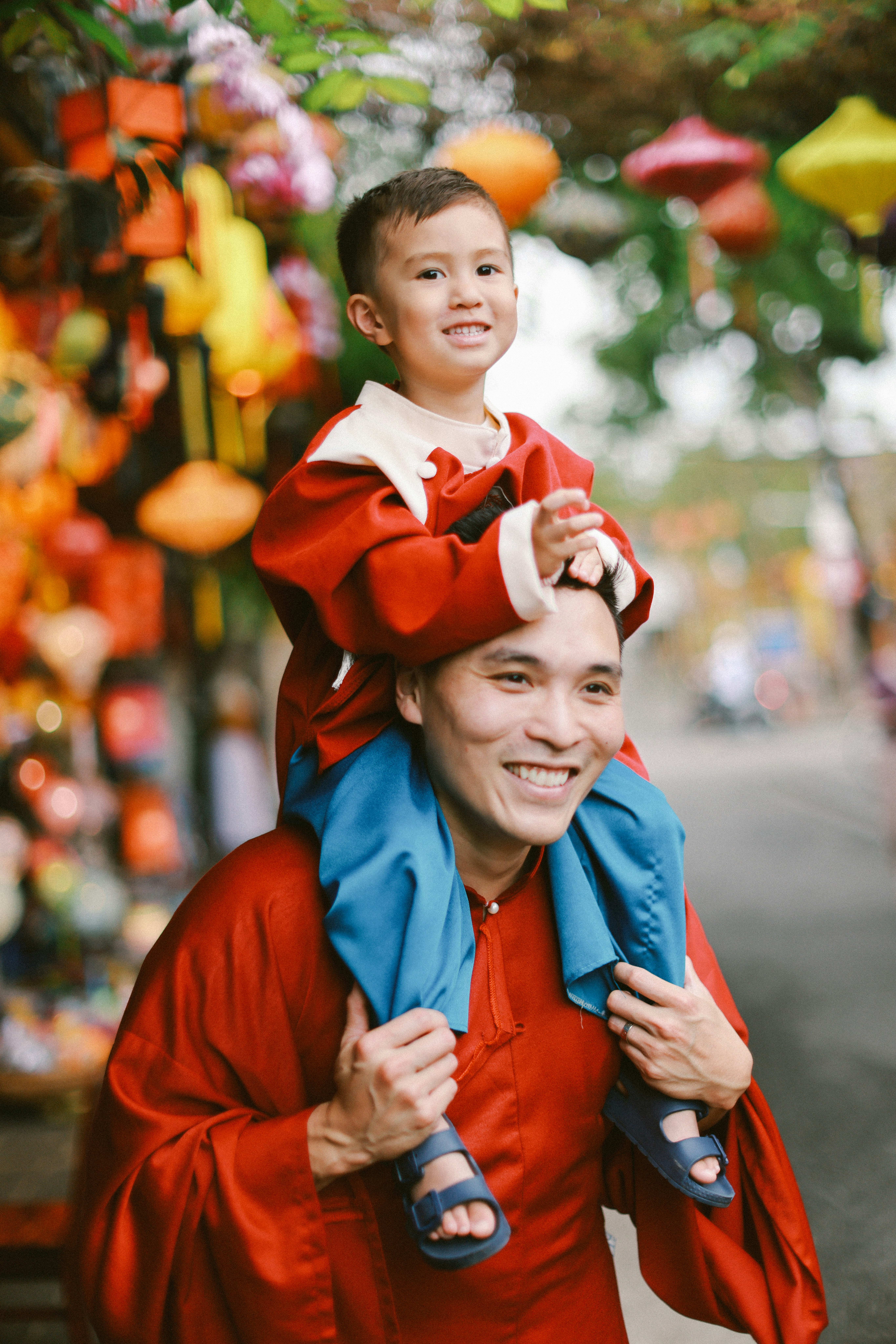 Father's Joy: A Child's Delight Riding on Dad's Shoulders Through Lantern-Light Streets