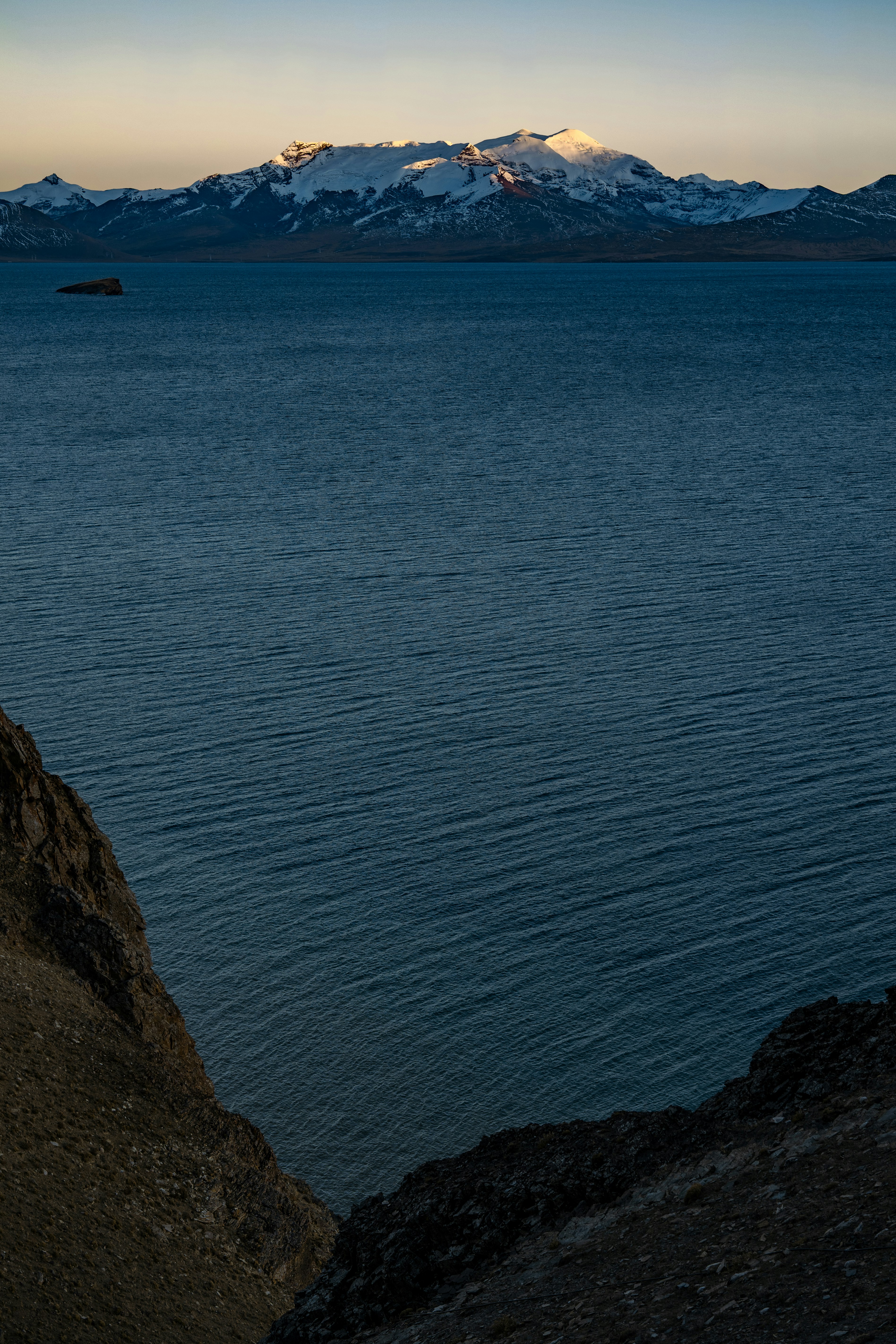 A Sea of Nightfall: Snow-Capped Edge Beneath a Calm Horizon