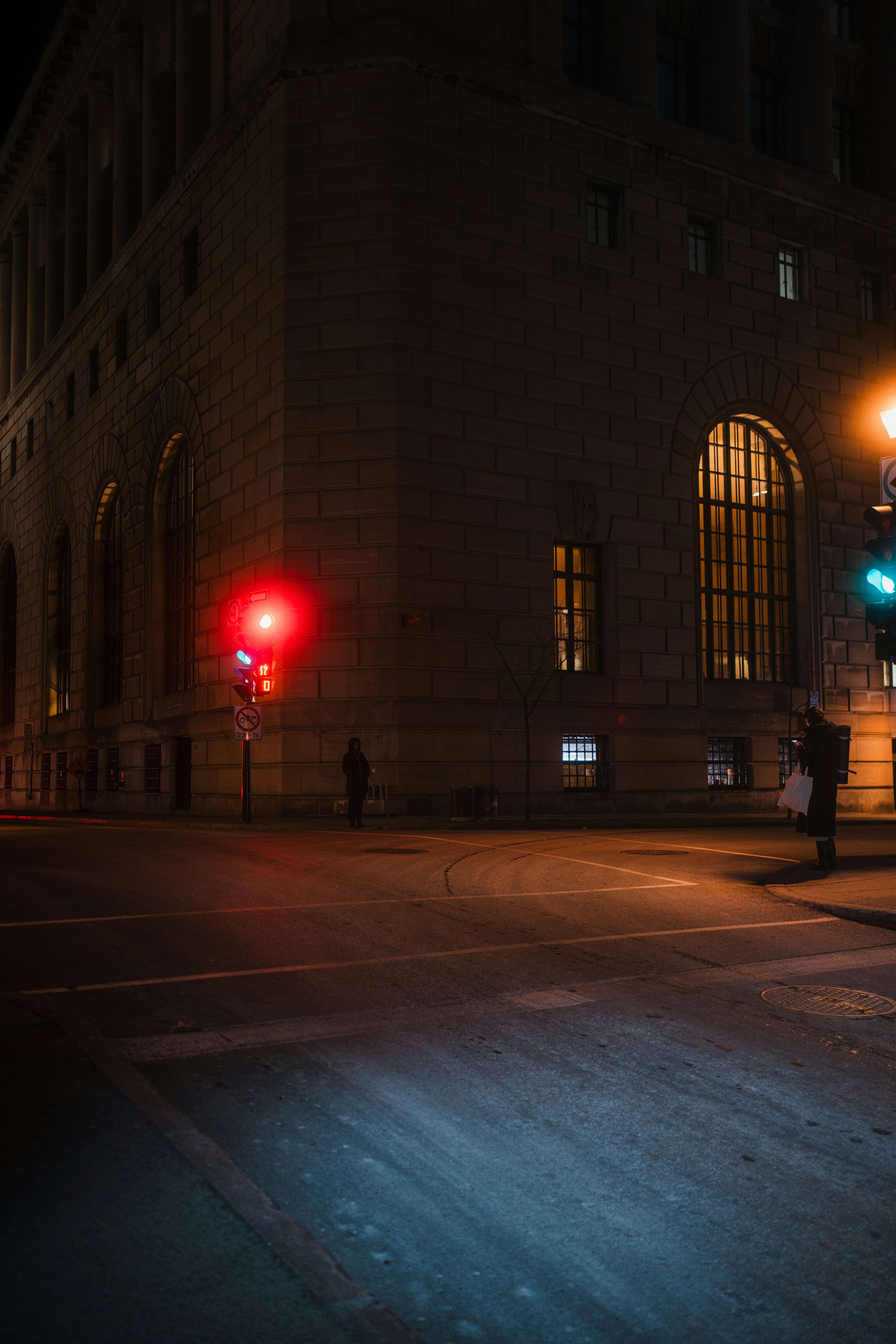 Red Traffic Light at a Corner of a Historic Building After Hours