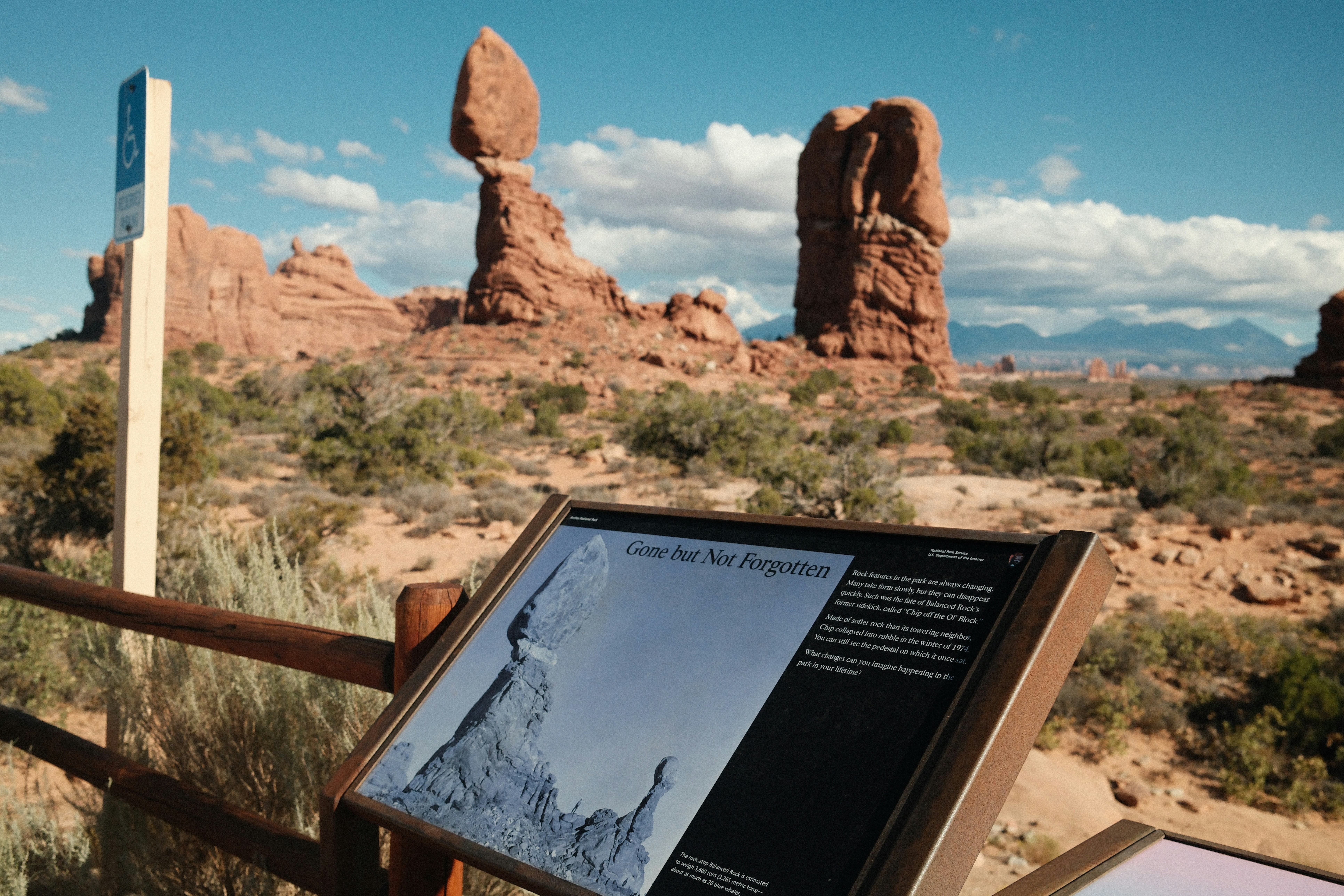 Desert Balance: Balanced Rock Formations Guarding an Informational Panel