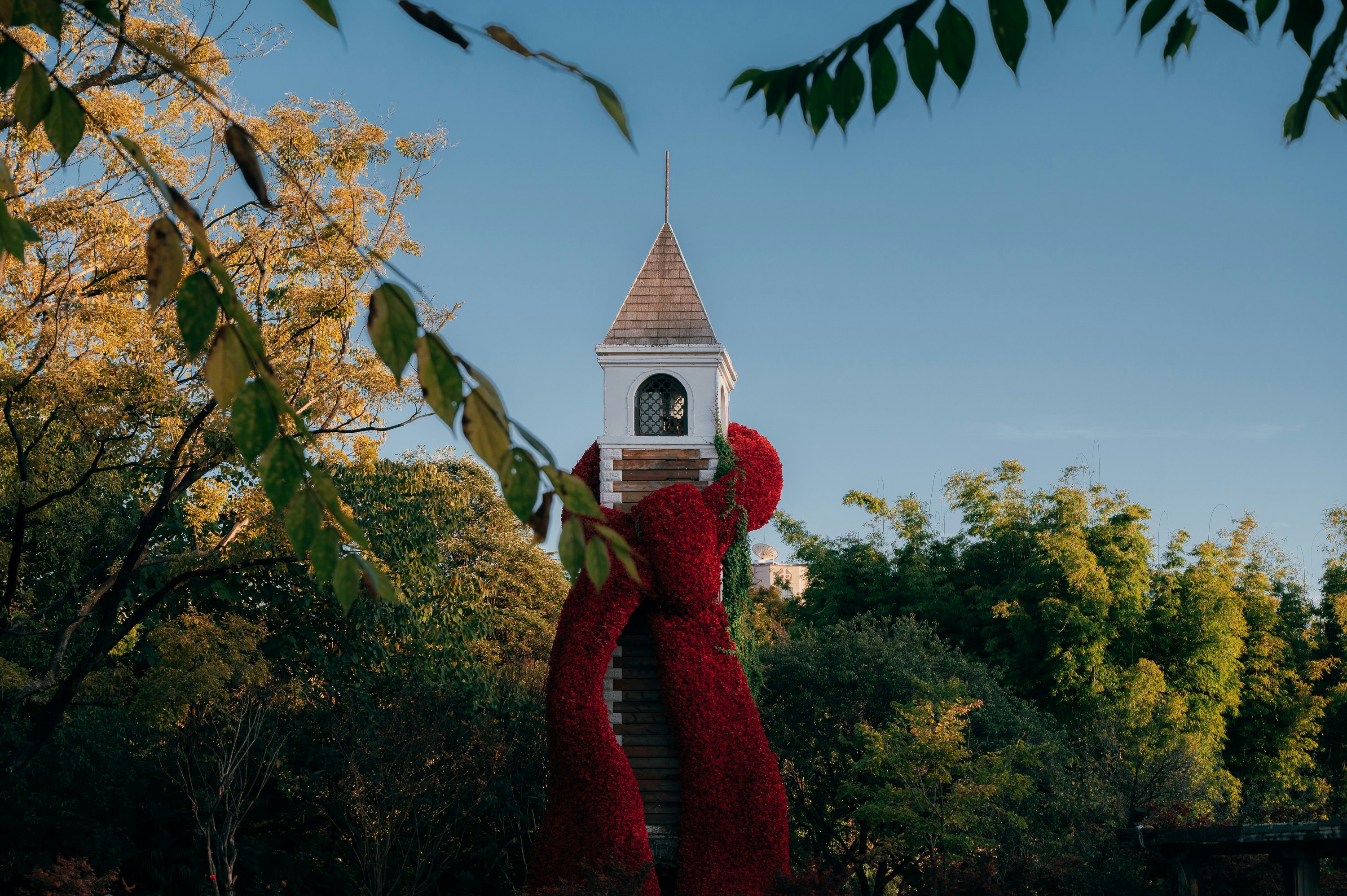 Red Sculpted Arch: A Tower Surrounded by Autumn Bloom