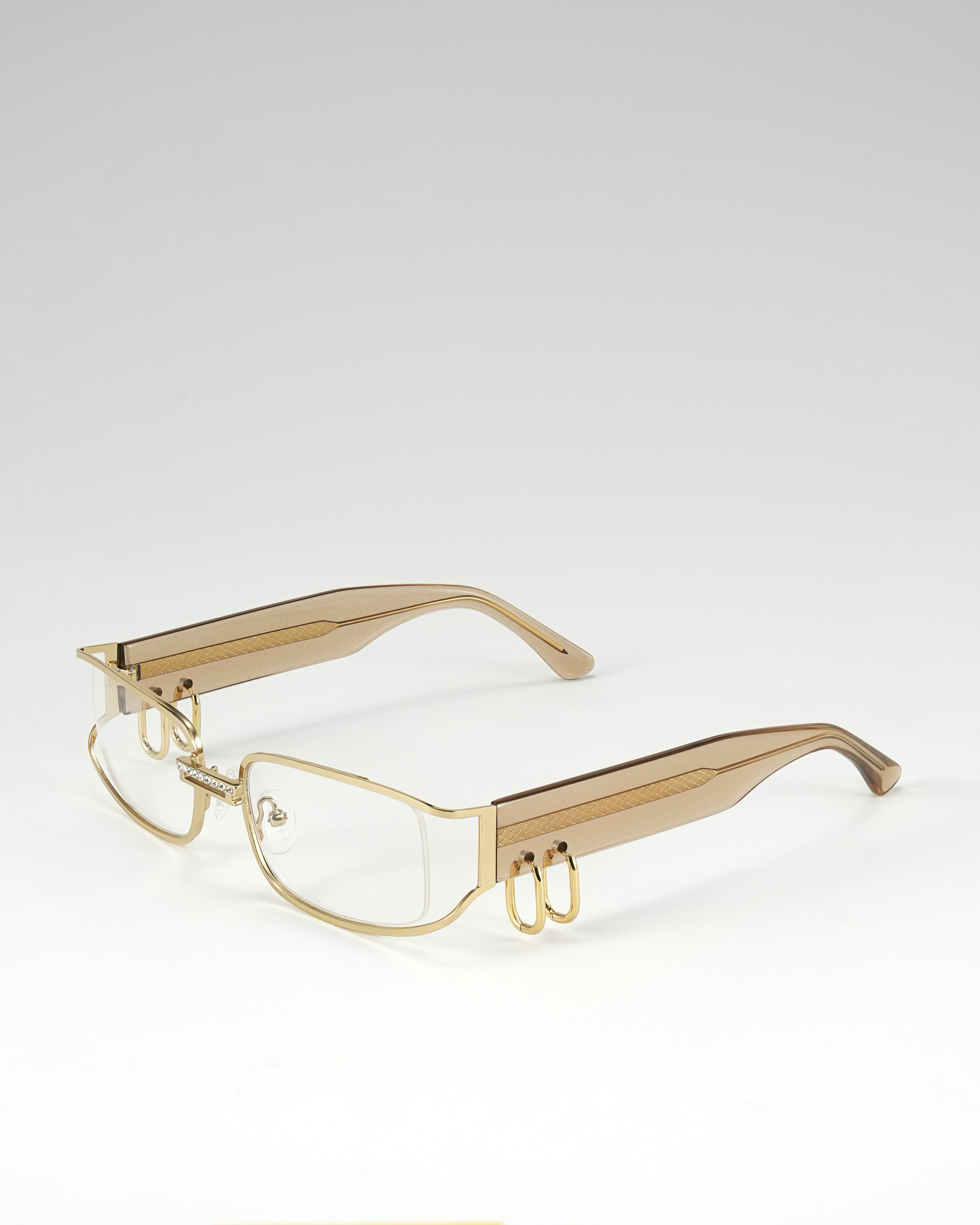 Gilded Eyewear: Retro-Rugged Frames Resting on White Studio Snow