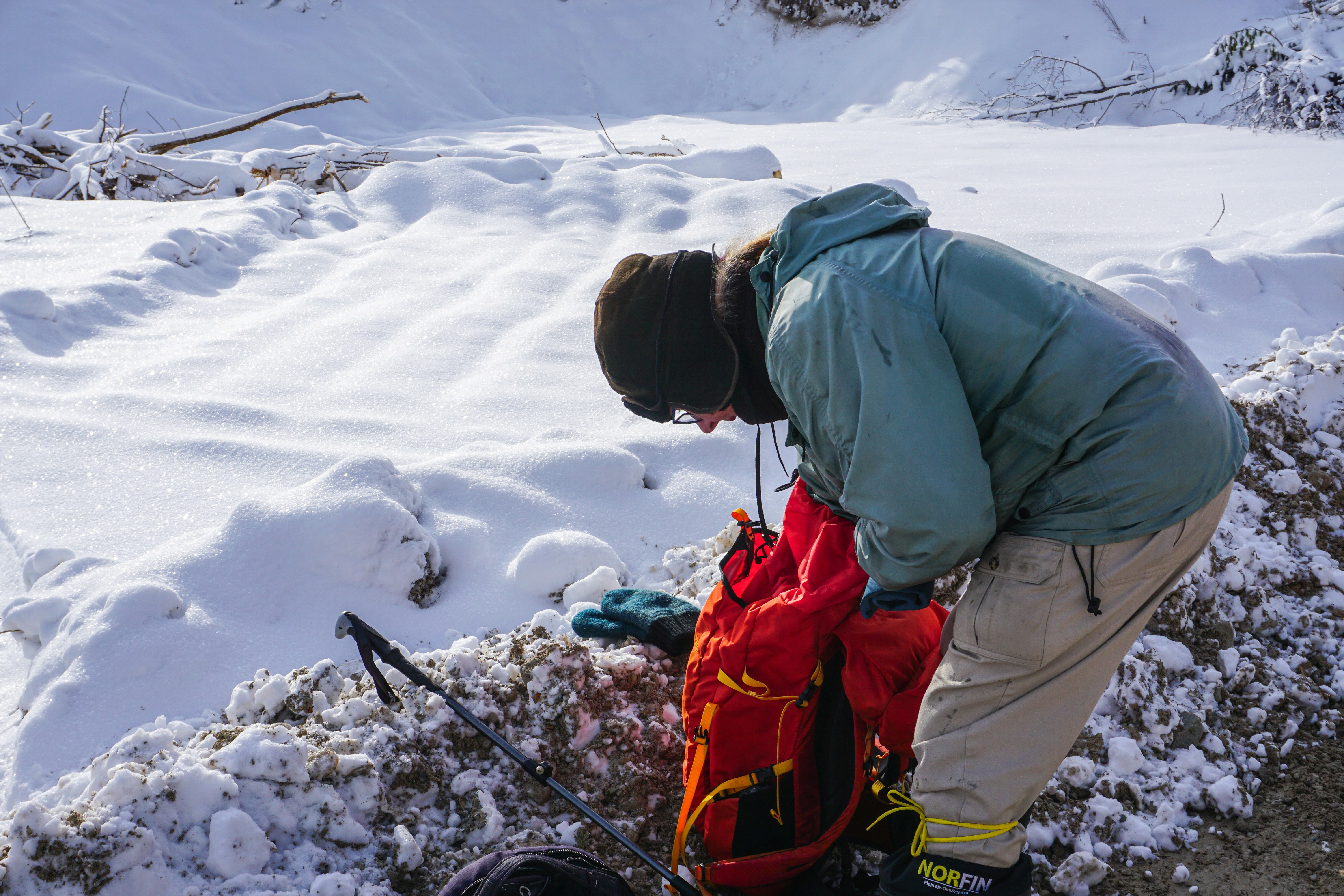 A hiker friend reaching for his lunch on a winter hike.