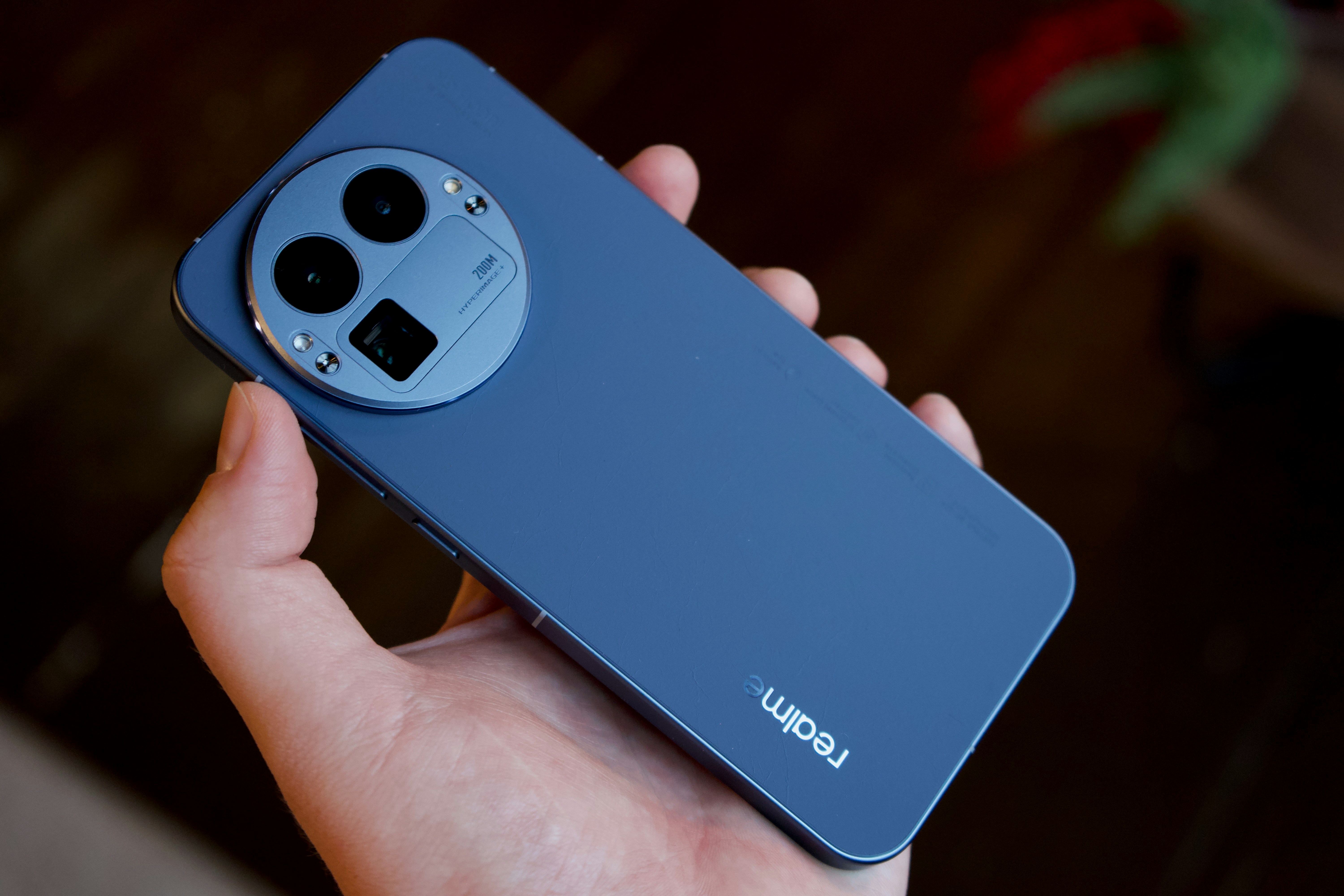 Hand holding a blue smartphone with a circular camera module. photo ...