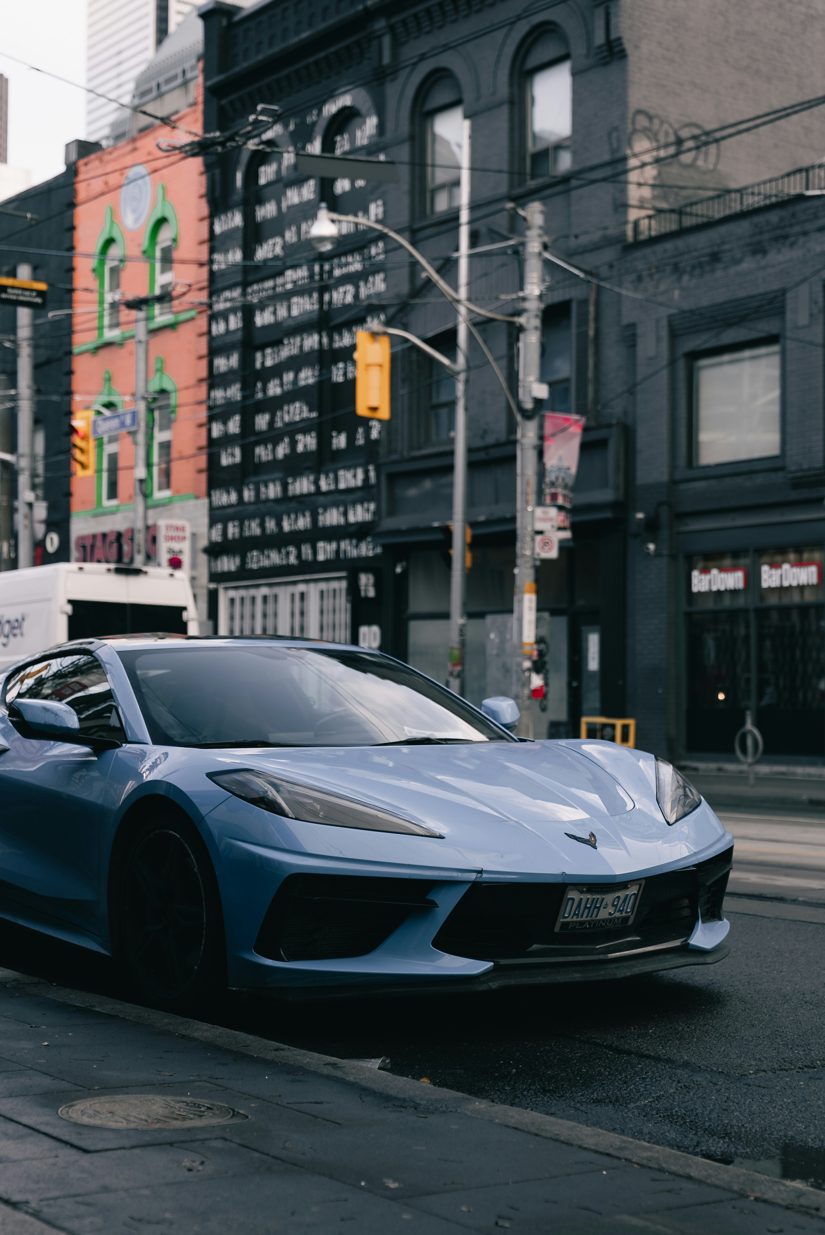 Blue Chevrolet Corvette Looms Over a City Street