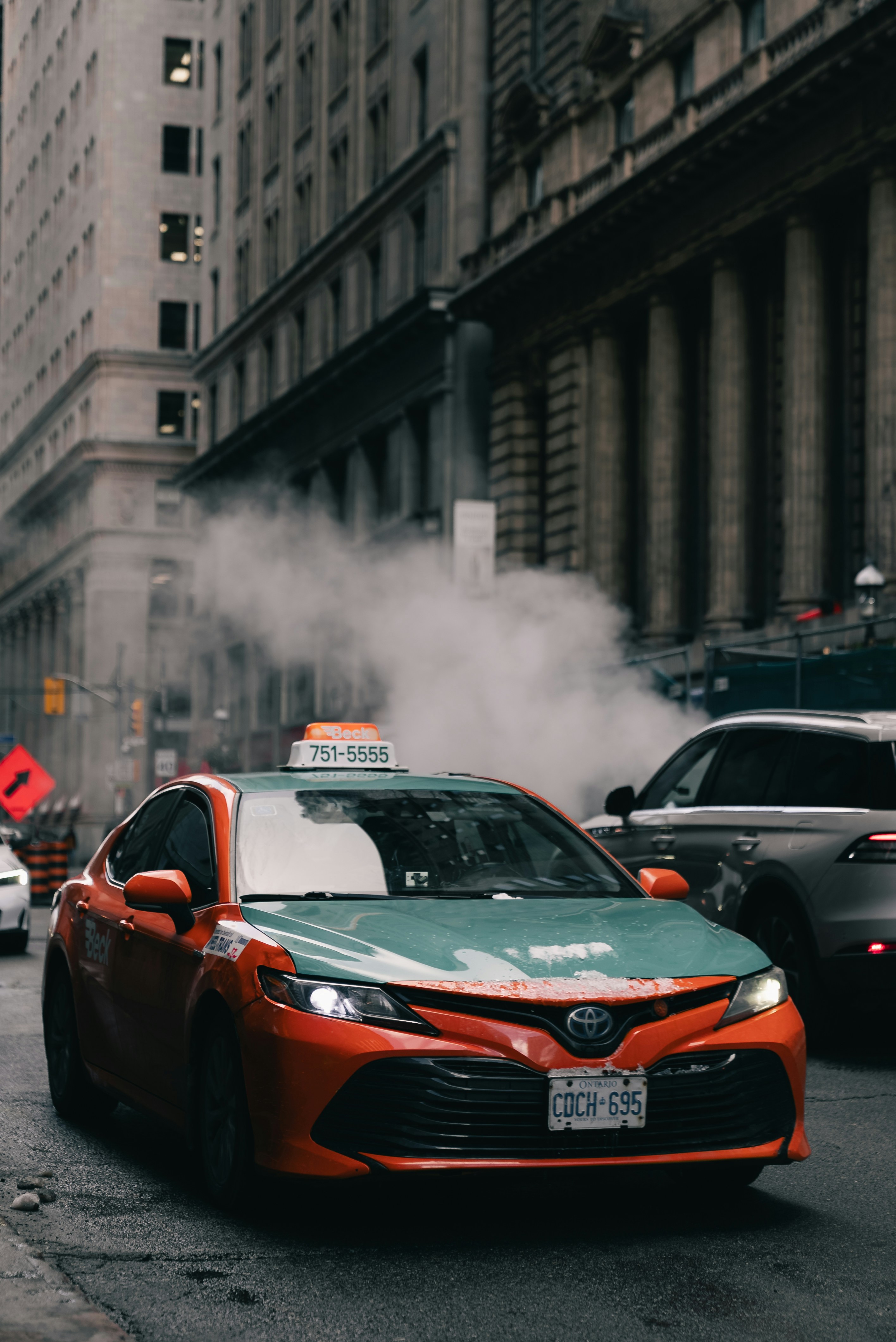 Street Pulse: The Orange-Topped Taxi Cutting Through Urban Steam
