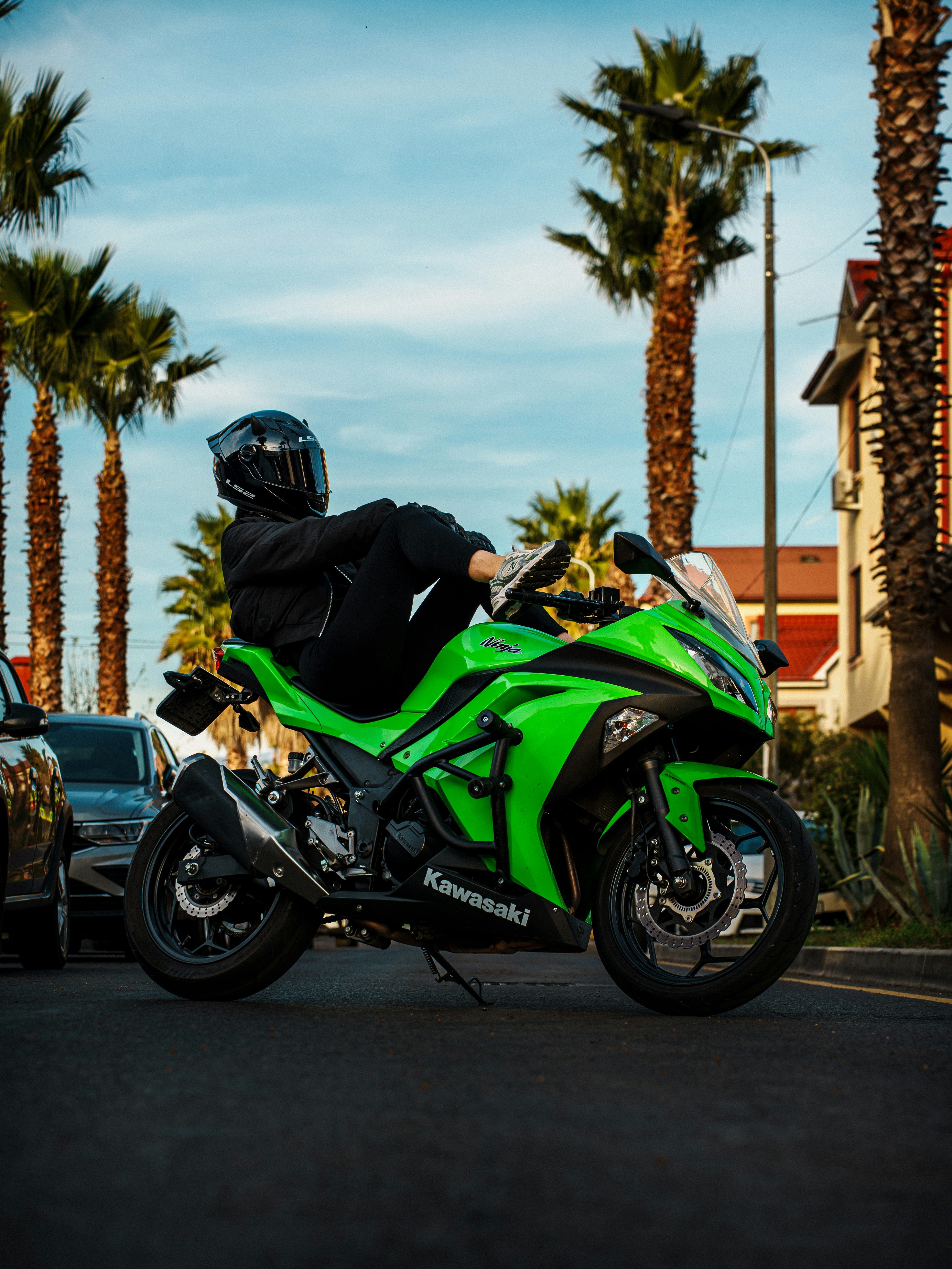 Green Ninja on the Street: a Kawasaki Stance under Palm Shadows
