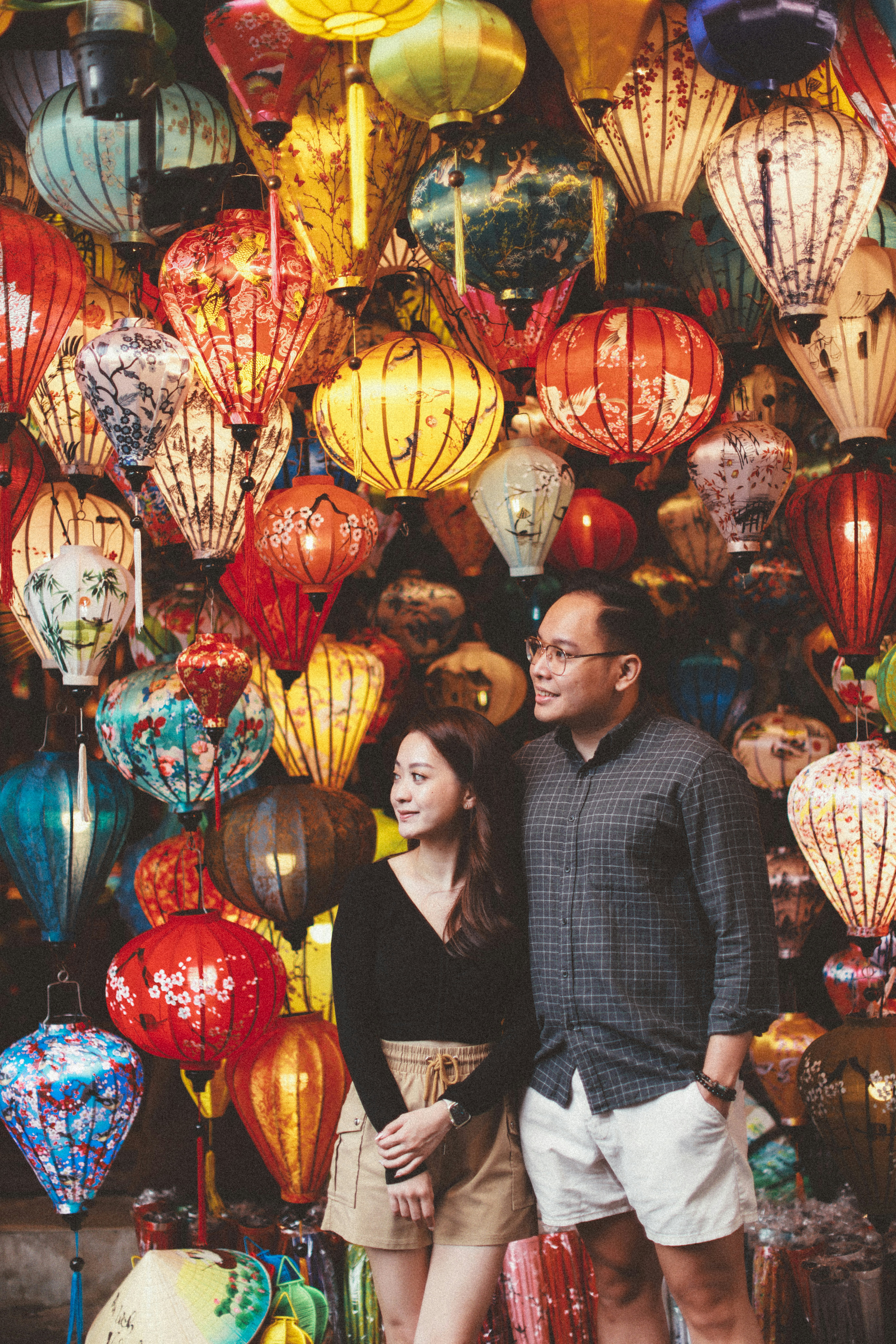 Lanterns and Lovers: A Moment Amidst a Ceiling of Color