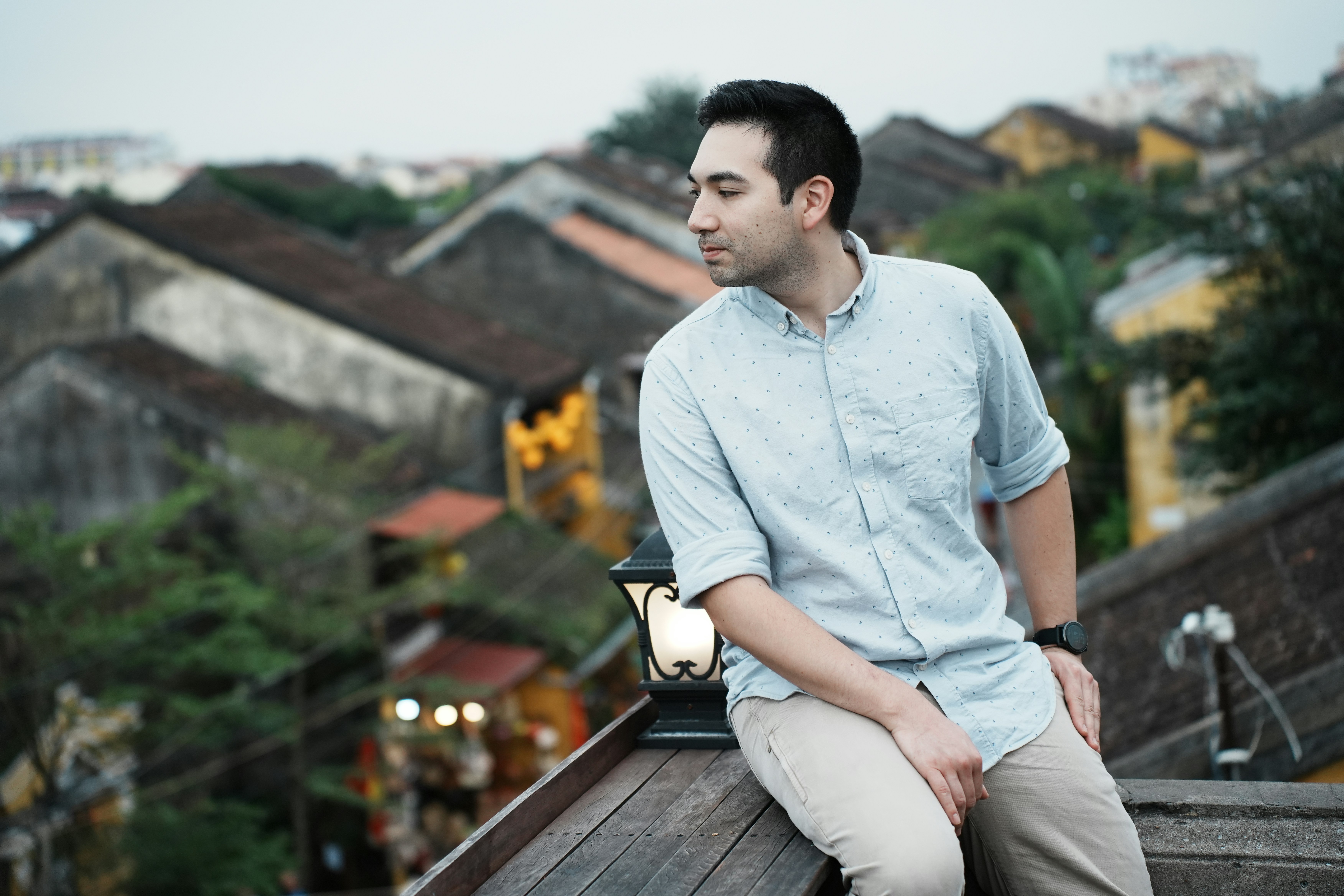 Smart-casual portrait on a village rooftop at dusk