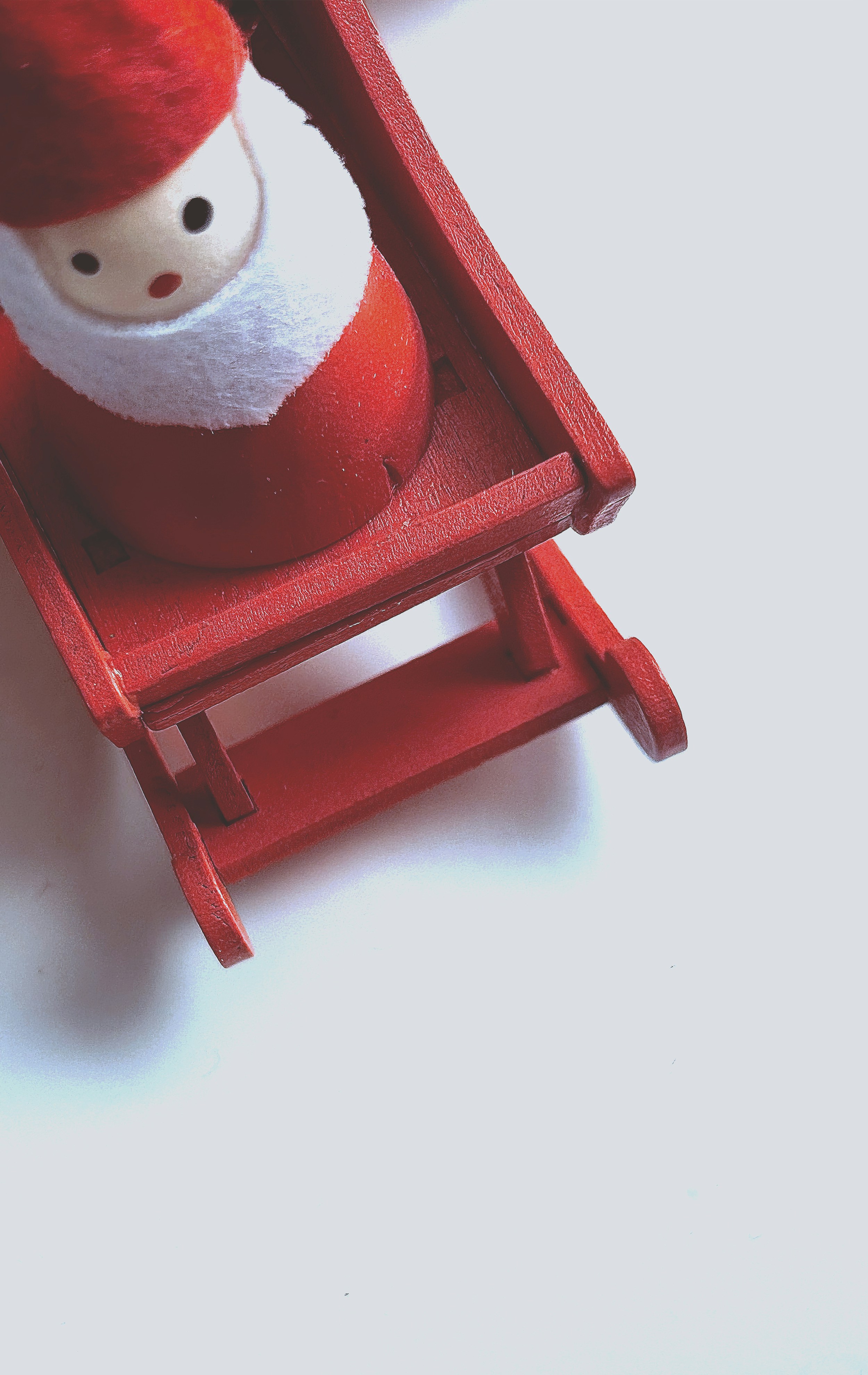 A small santa claus figure in a red sleigh.