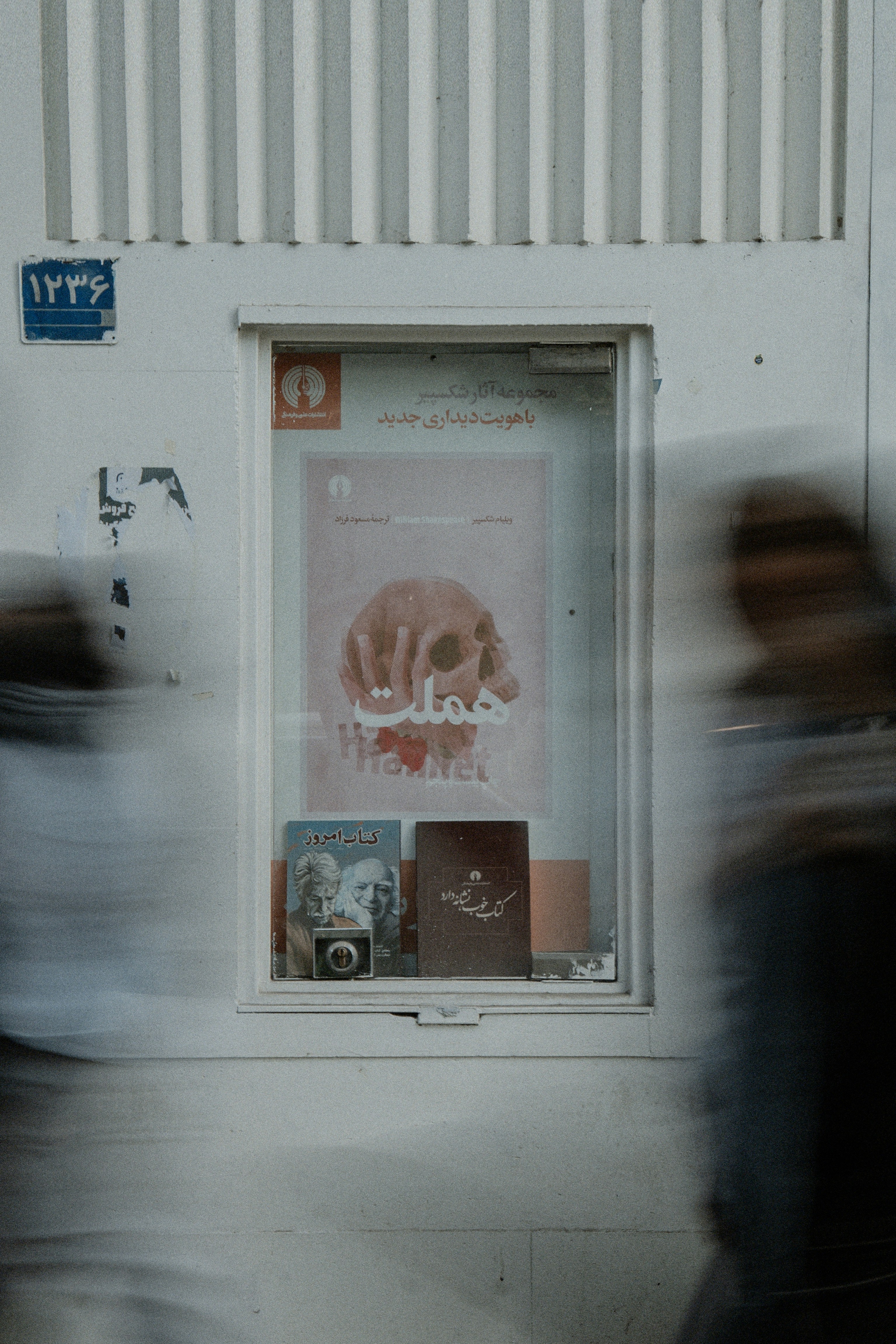 Poster Window in Motion: Blurred Passersby in a Street Scene