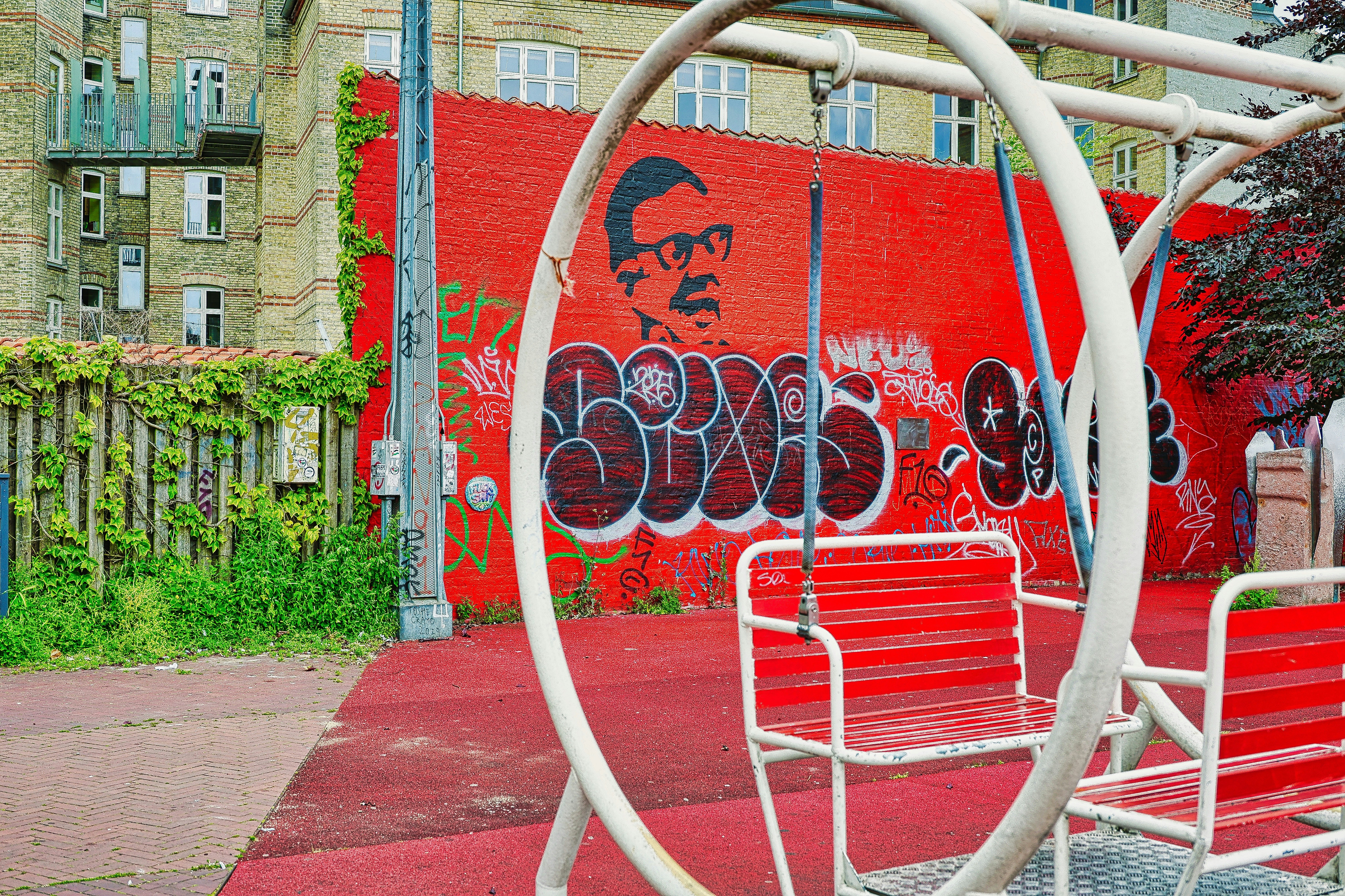 Graffiti Wall as Backdrop: Circular Swing Frame Framing an Urban Puzzle