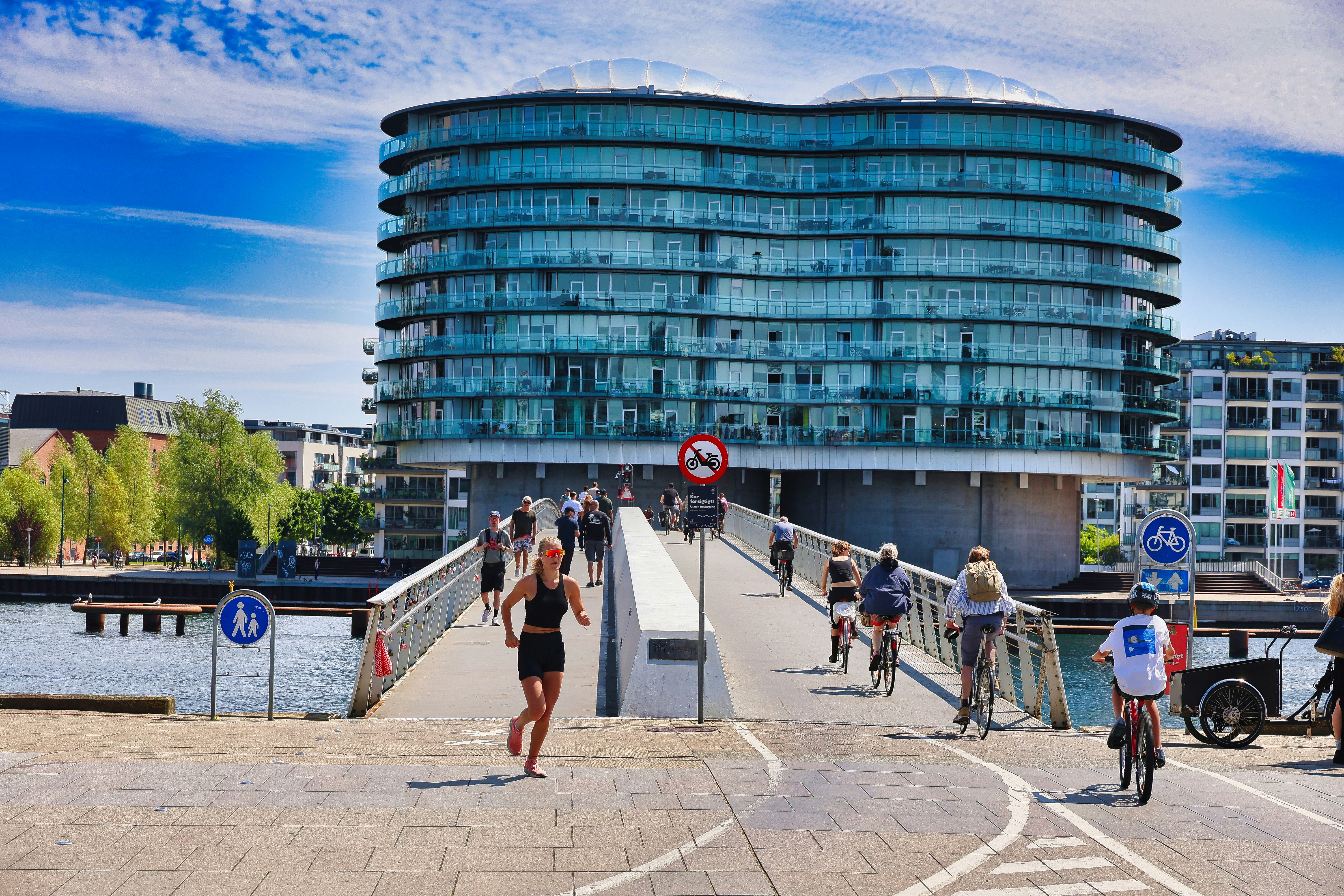 People crossing a modern bridge towards a glass building. photo – Free ...