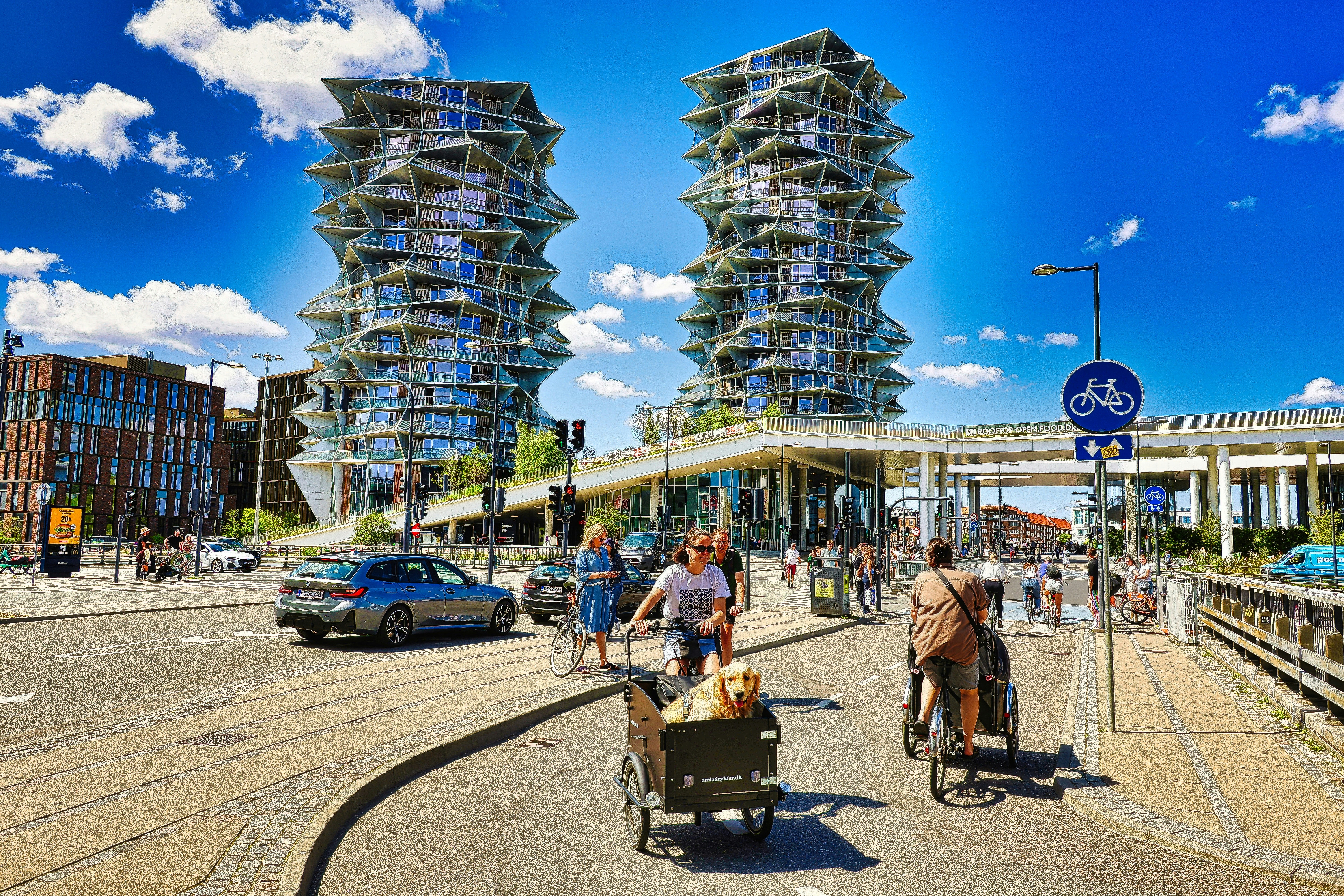 Two twisting towers rise above a bustling bike-forward urban square