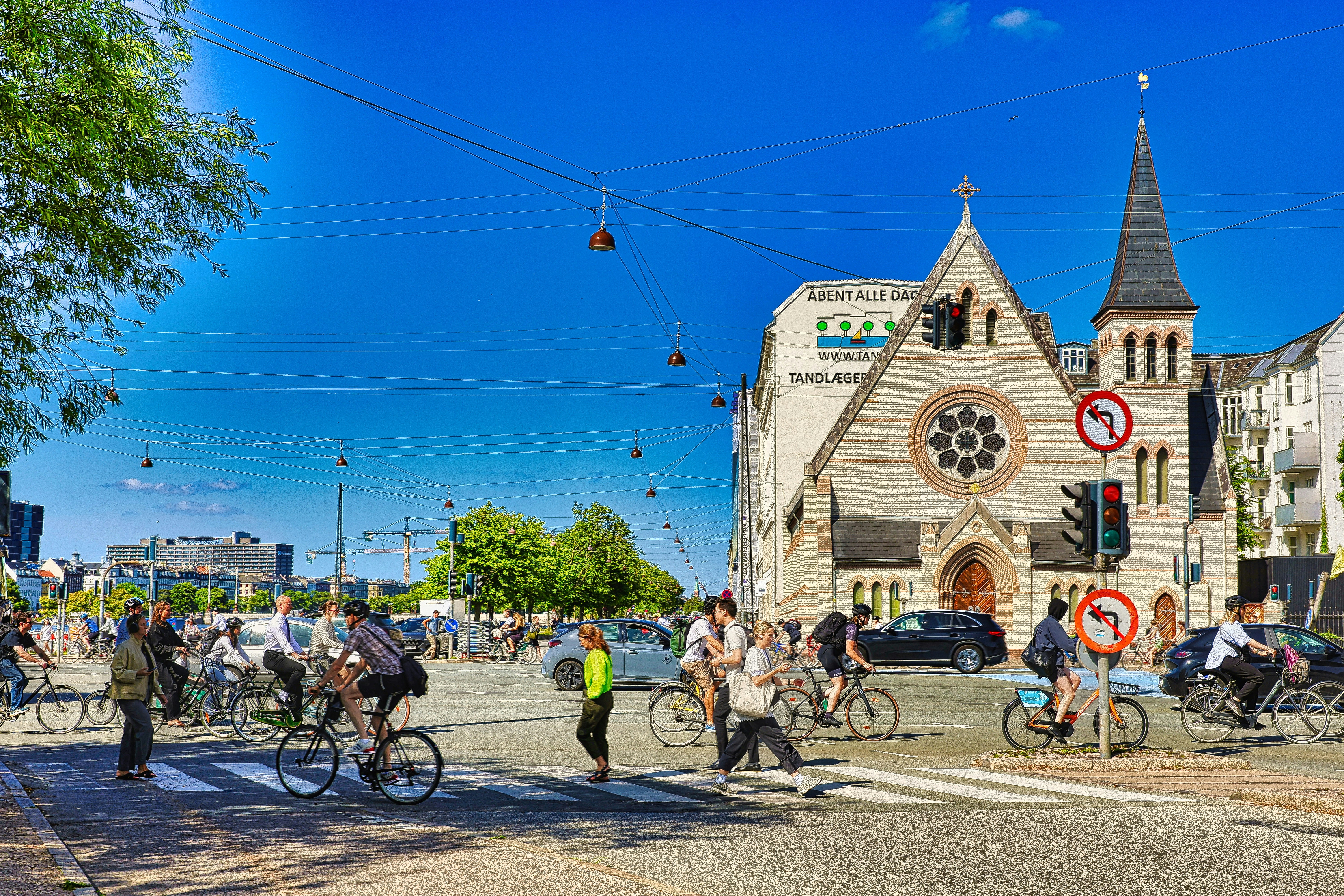 Crosswalk Ballet: Cyclists and Pedestrians in Front of a Gothic Church