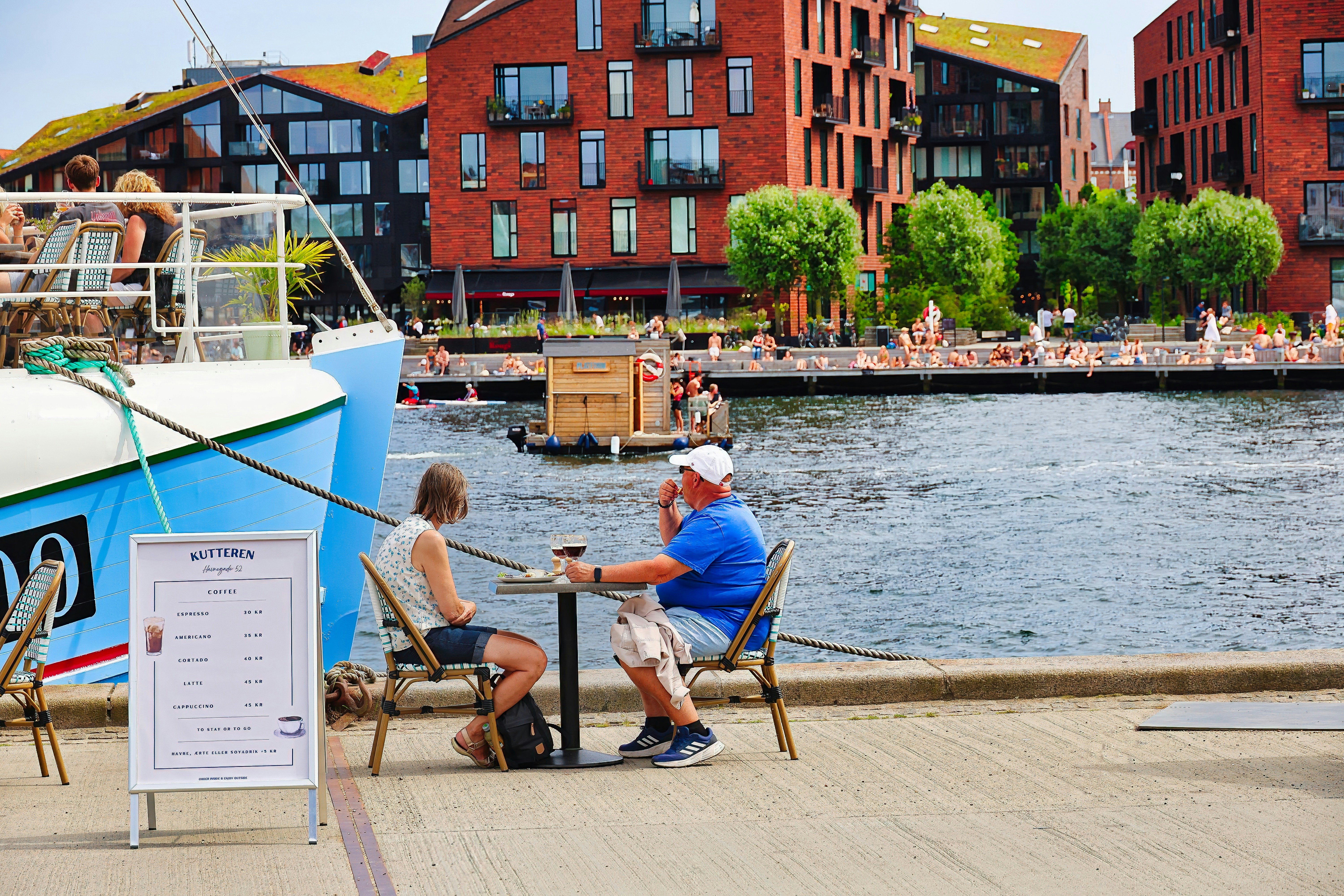 Conversation by the Waterfront: A Pair Chat in Front of Modern Townhouses