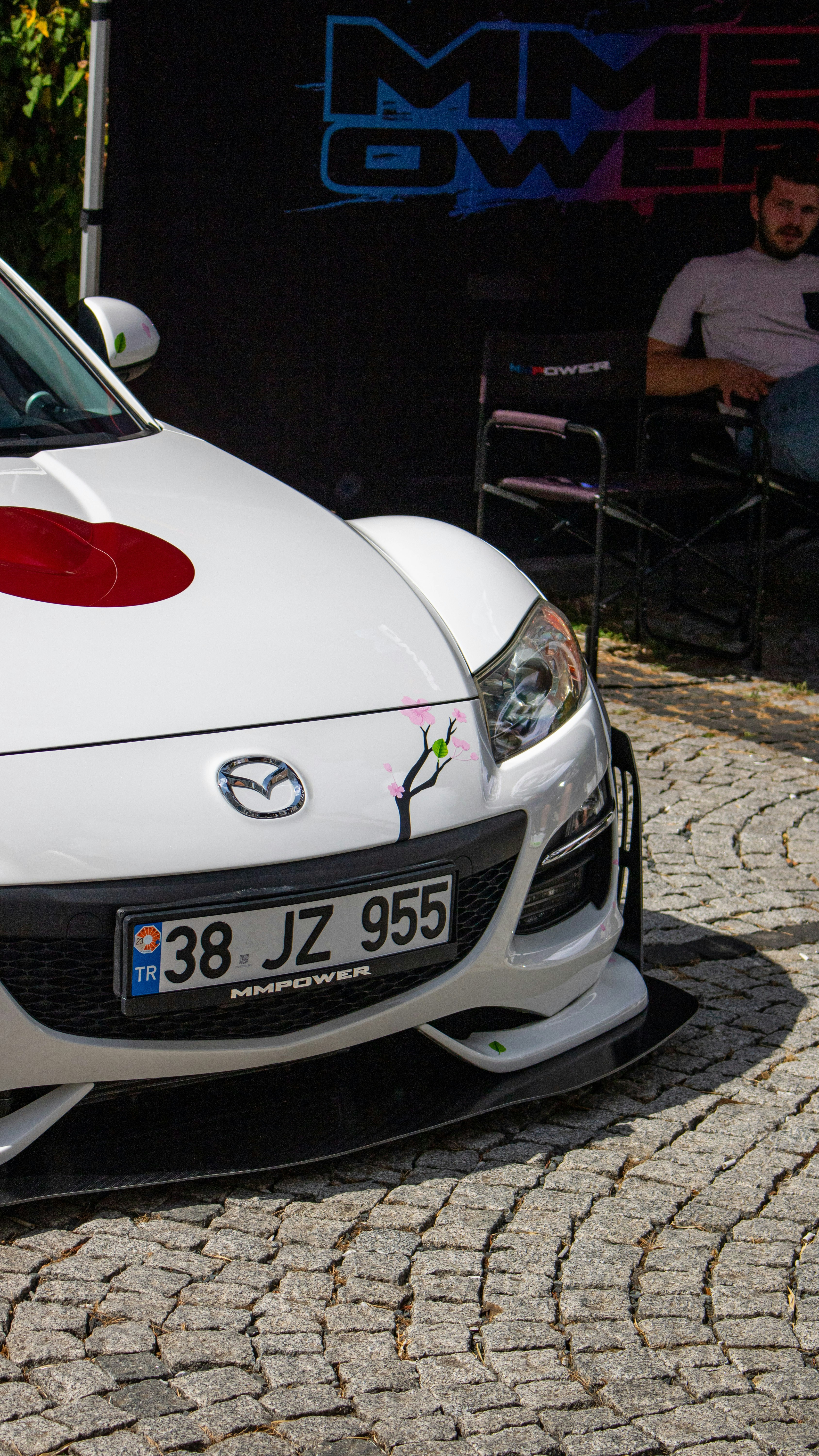 White Mazda with Cherry Blossom Accent Anchors a Car Show Scene