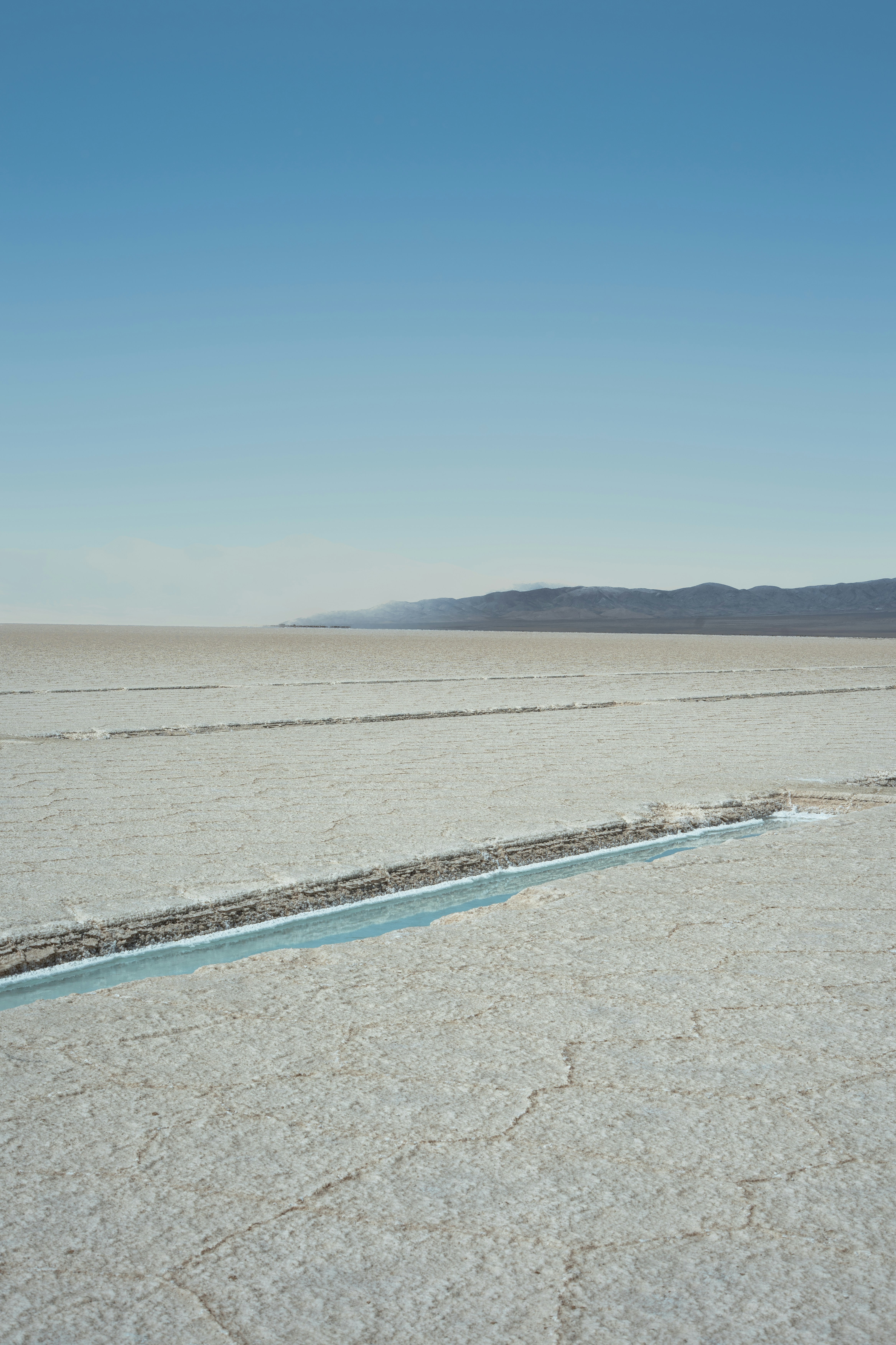 Macro shot of crystallized salt formations sparkling under strong sunlight.