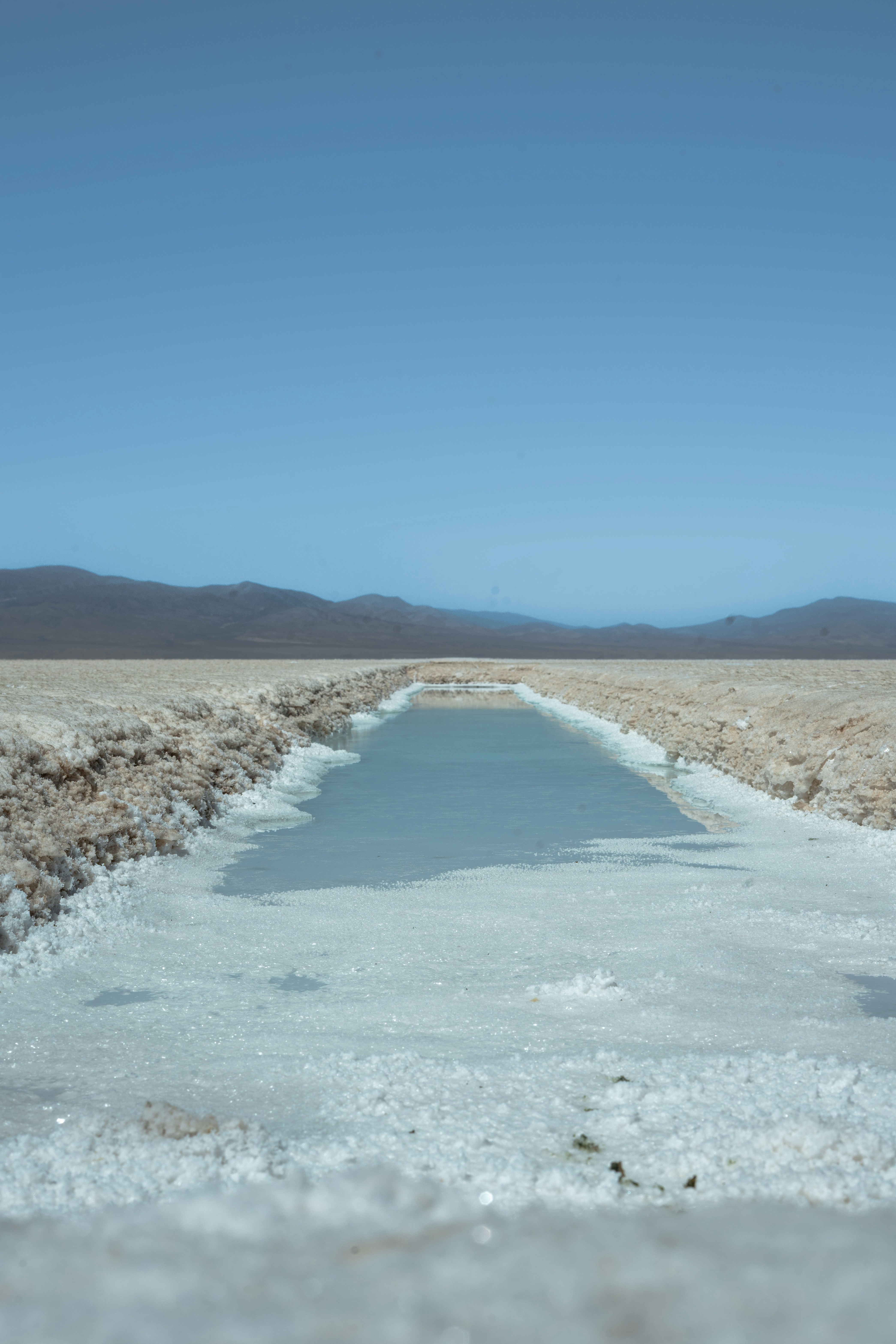 Detailed salt crystal texture forming natural geometric shapes on the desert floor.