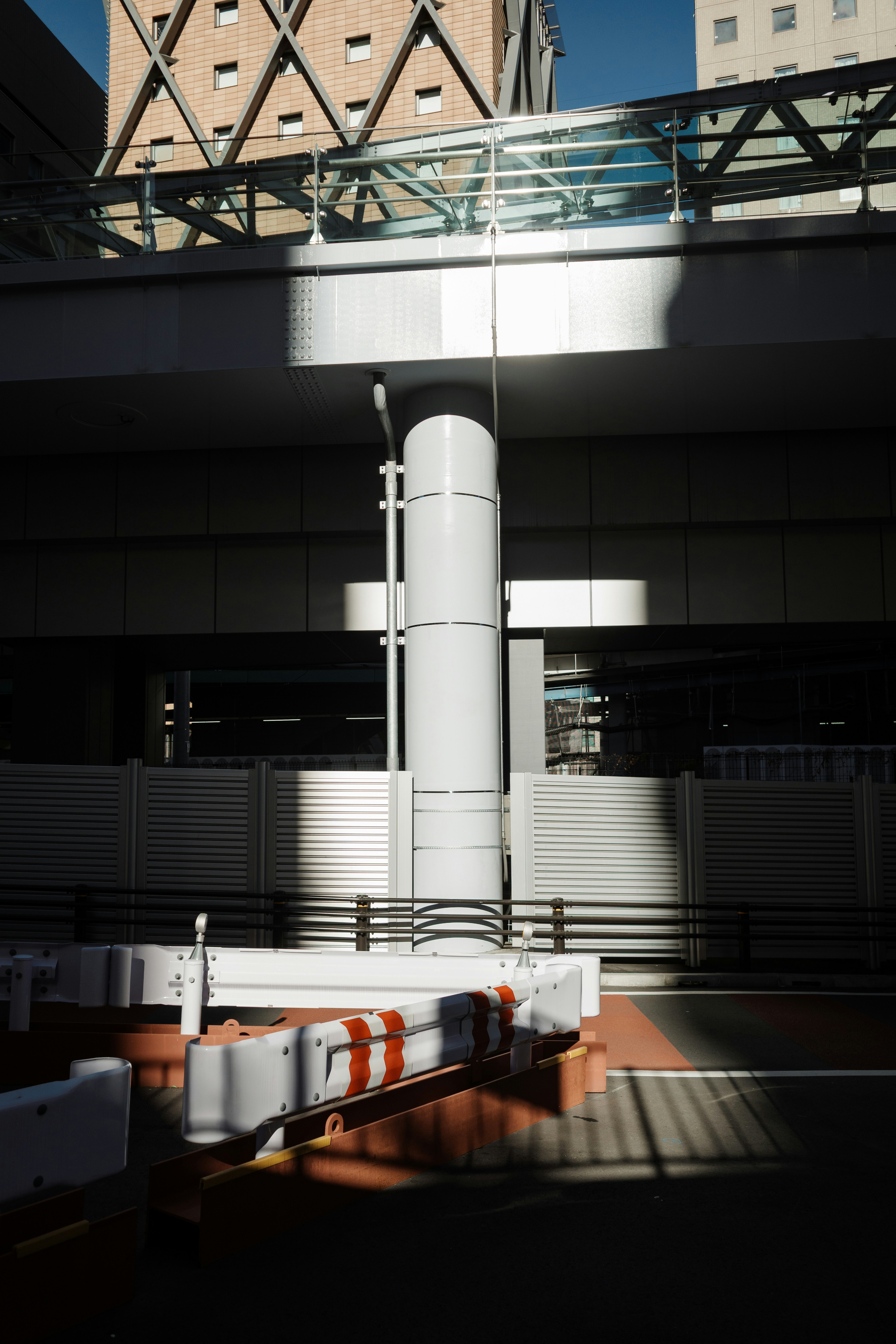 Shadowed Pillar Beneath a Glass Skywalk