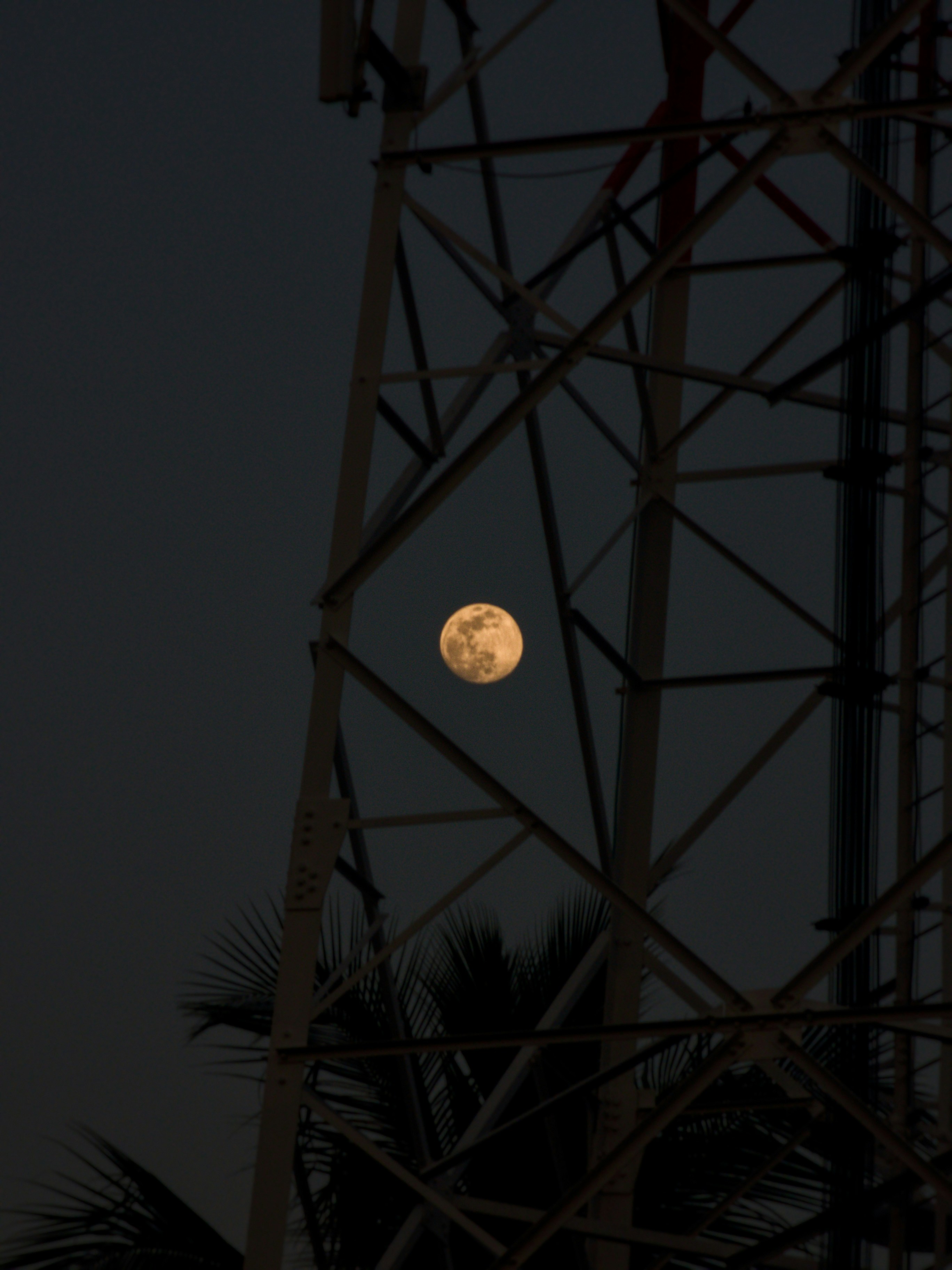 Full moon visible through a metal tower structure. photo – Free Space ...