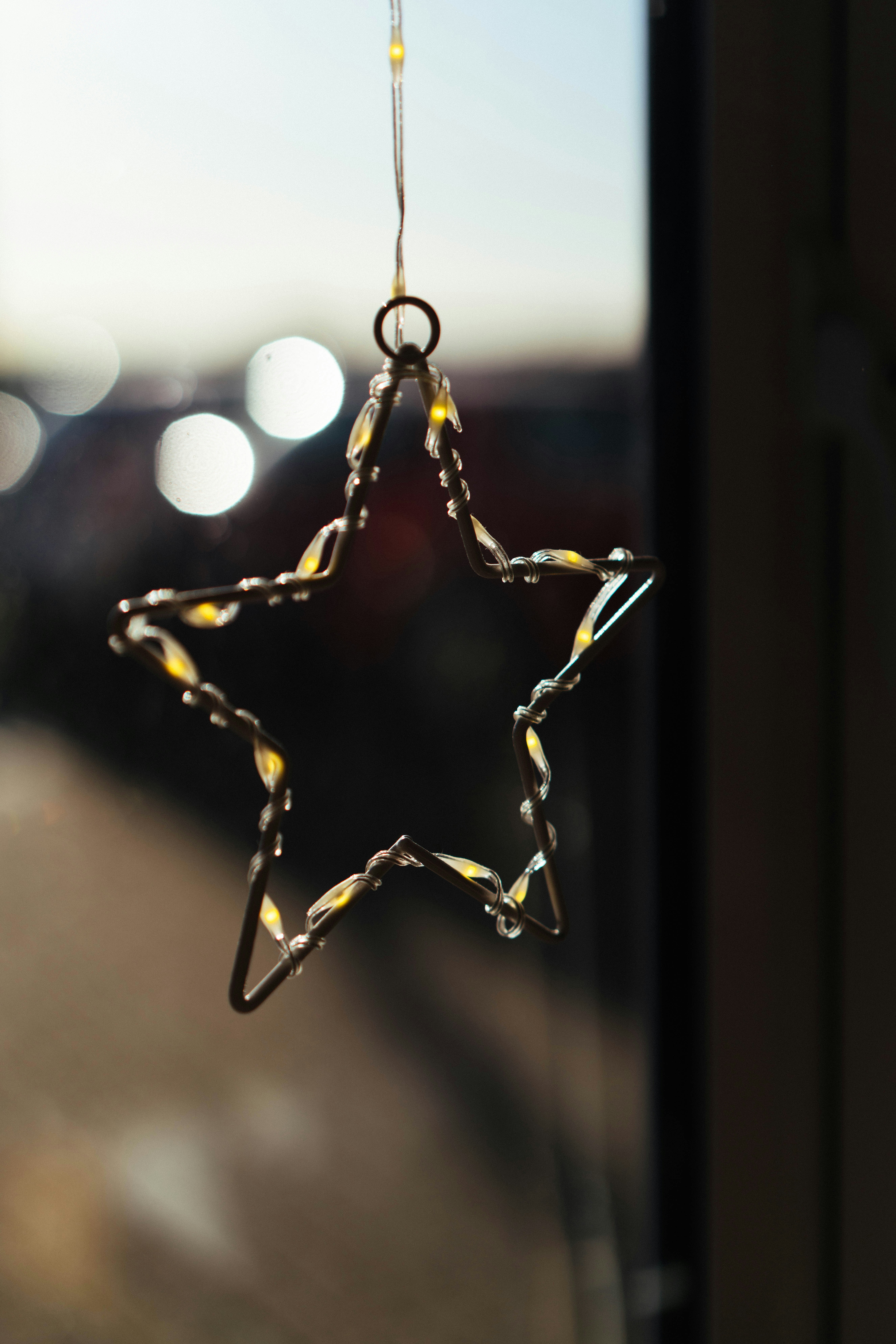 Hanging Star: A Simple Wire Star Adorns the Window at Dusk
