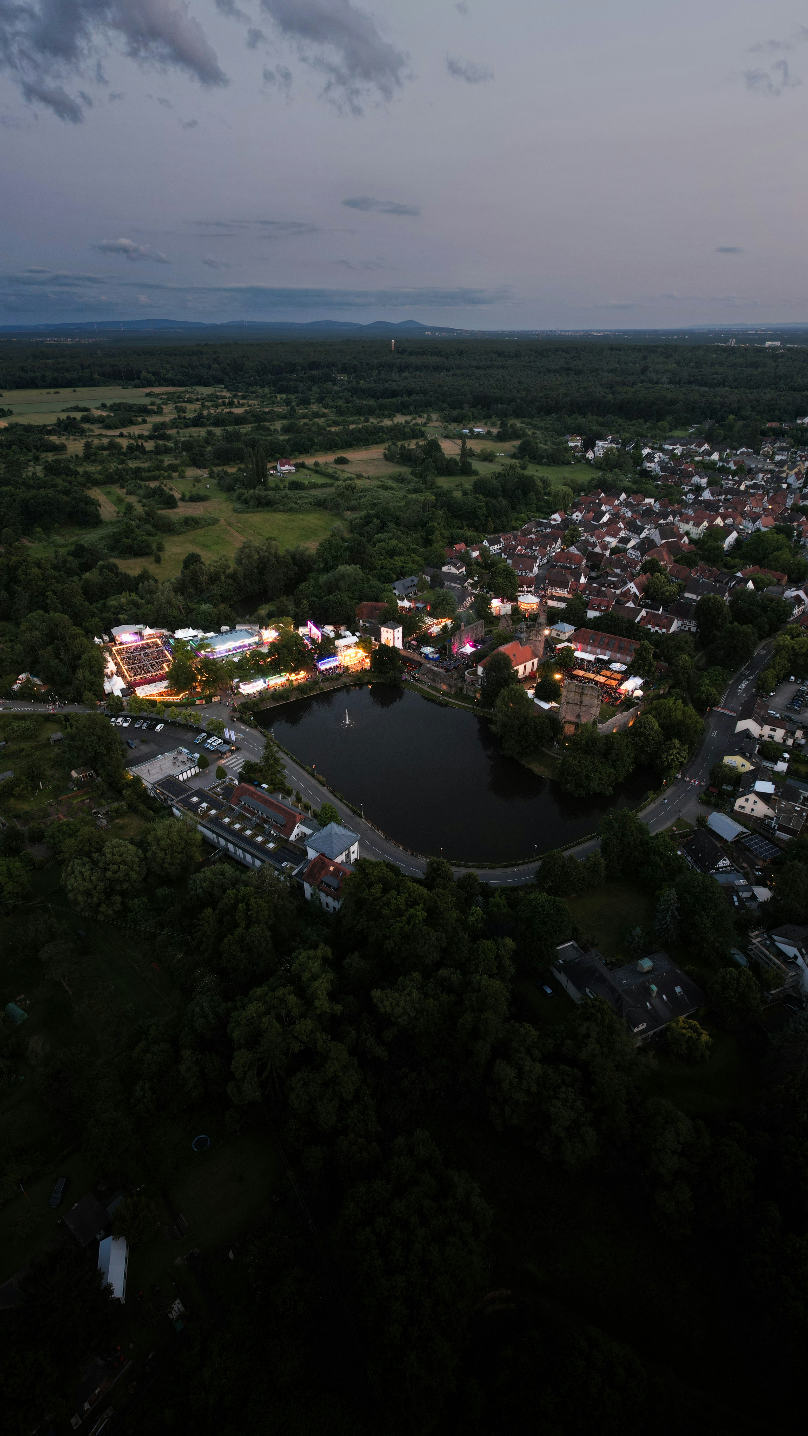 Twilight Village Ring: Aerial Sunset Over a Courtyard Lake
