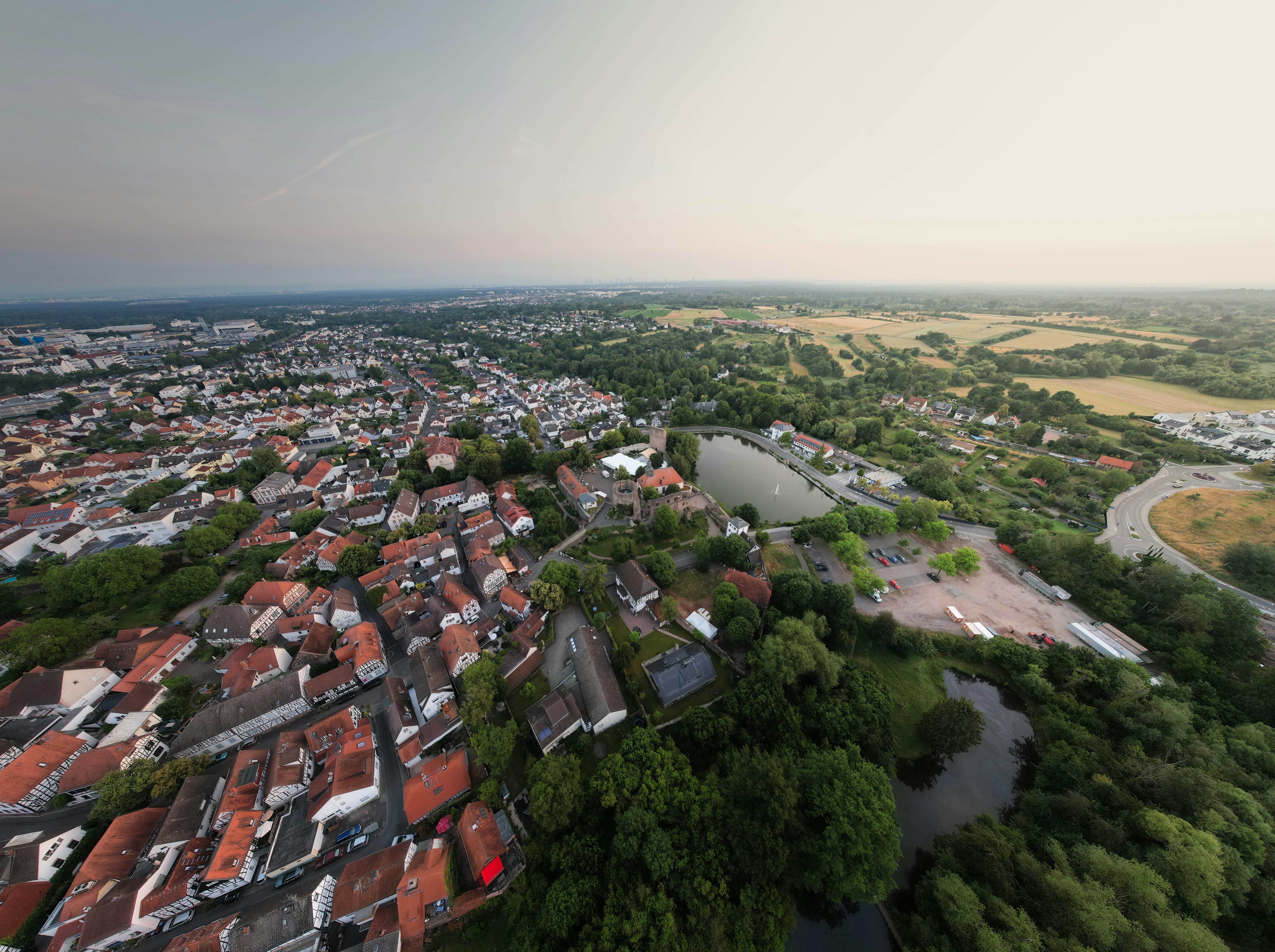 Aerial canvas: village rooftops spilling into green fields