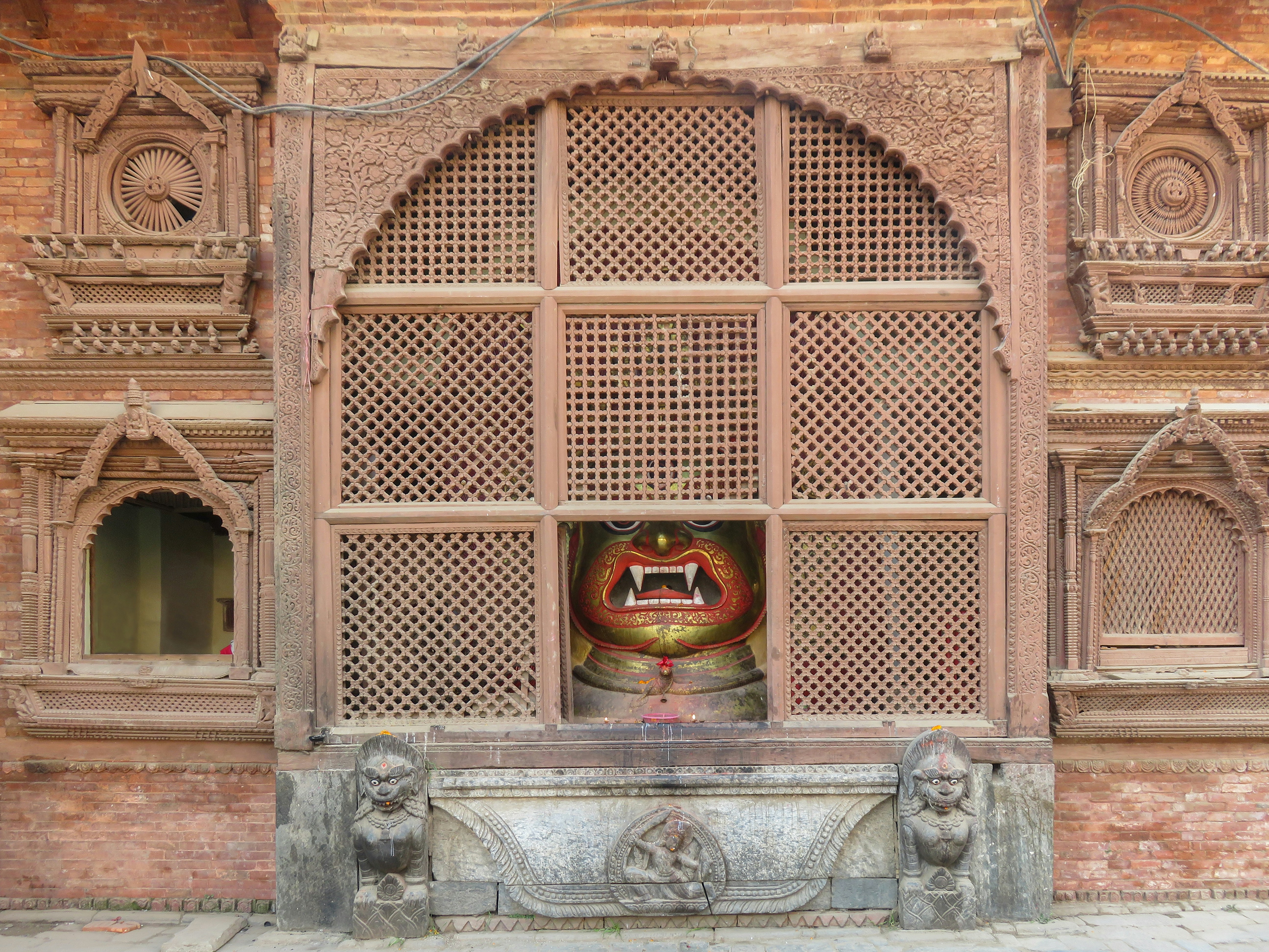 Giant sculpture of Swet Bhairav, the white Bhairava, behind the latticed window, in Kathamdu (Nepal).