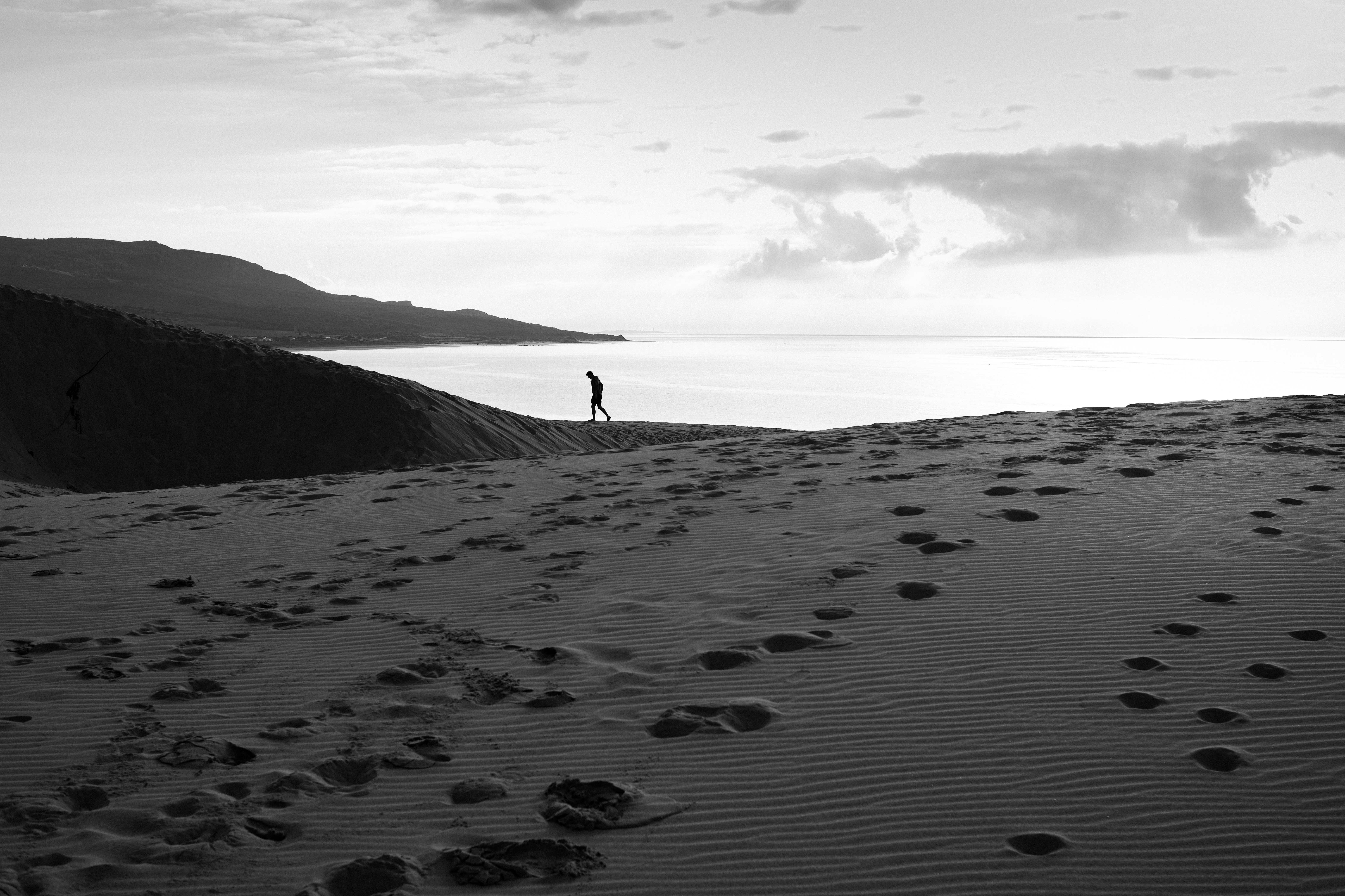 Footprints to the Horizon: A Lone Traveler on Wind-Washed Sand