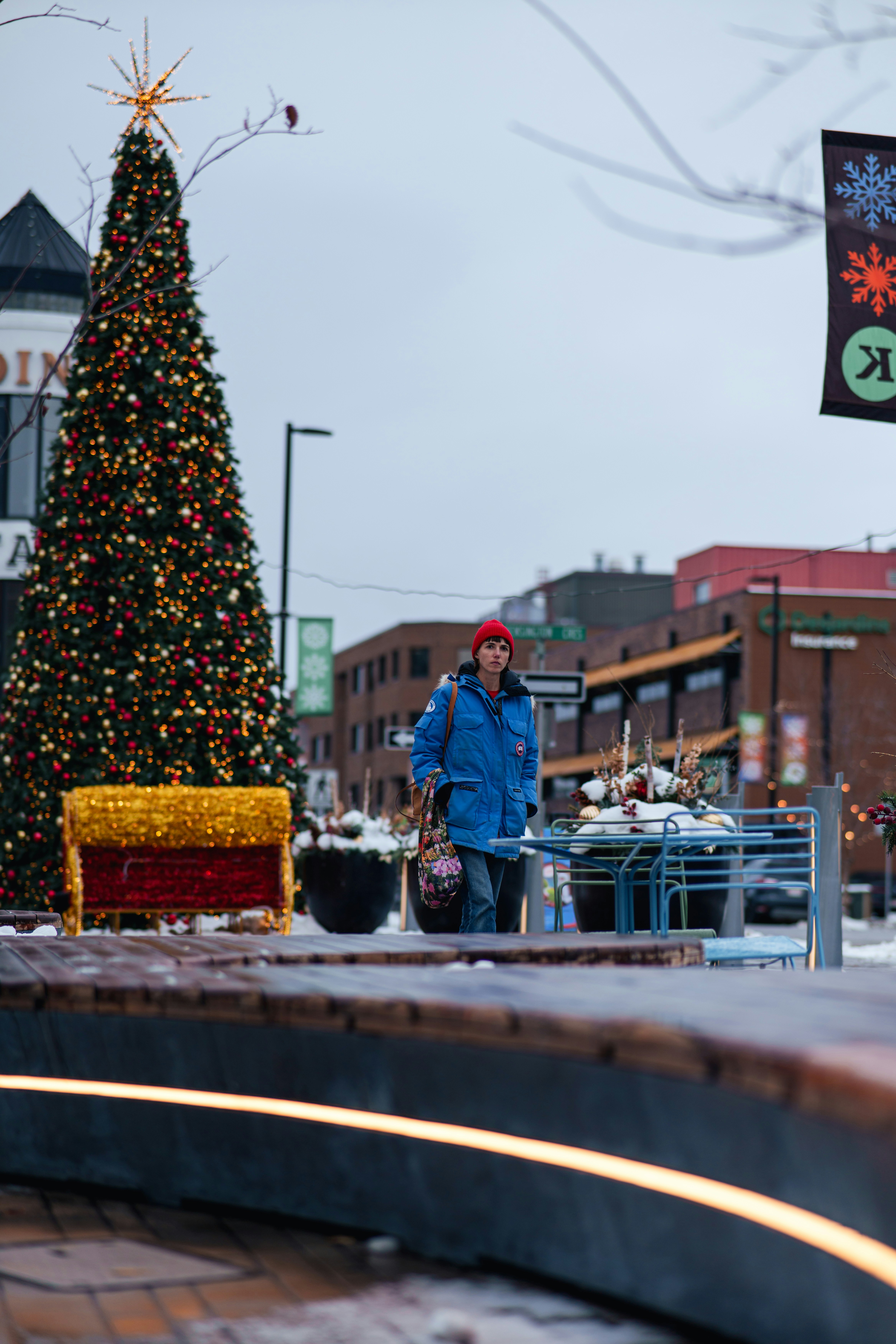Winter Street Quiet: Child in Blue Near the Christmas Tree