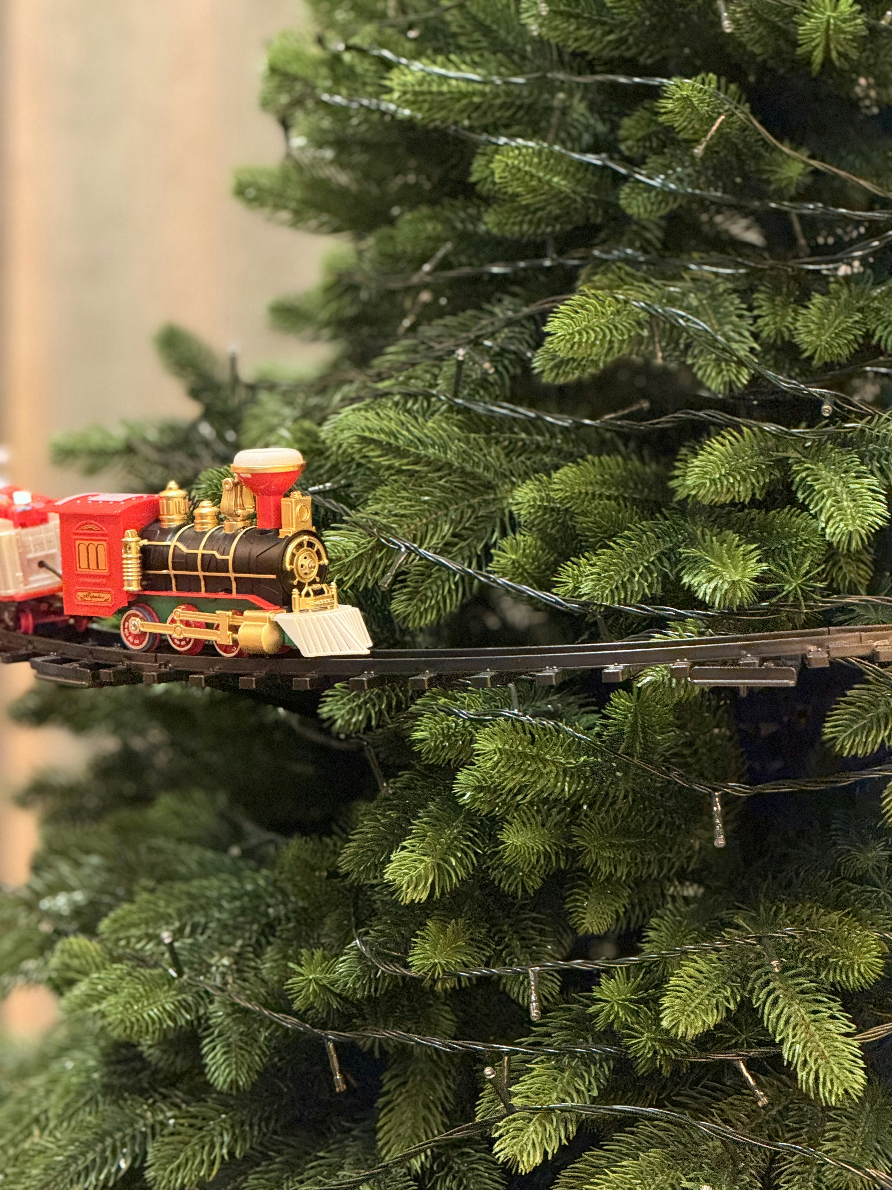 Toy train on tracks around a christmas tree photo – Free Winter Image ...