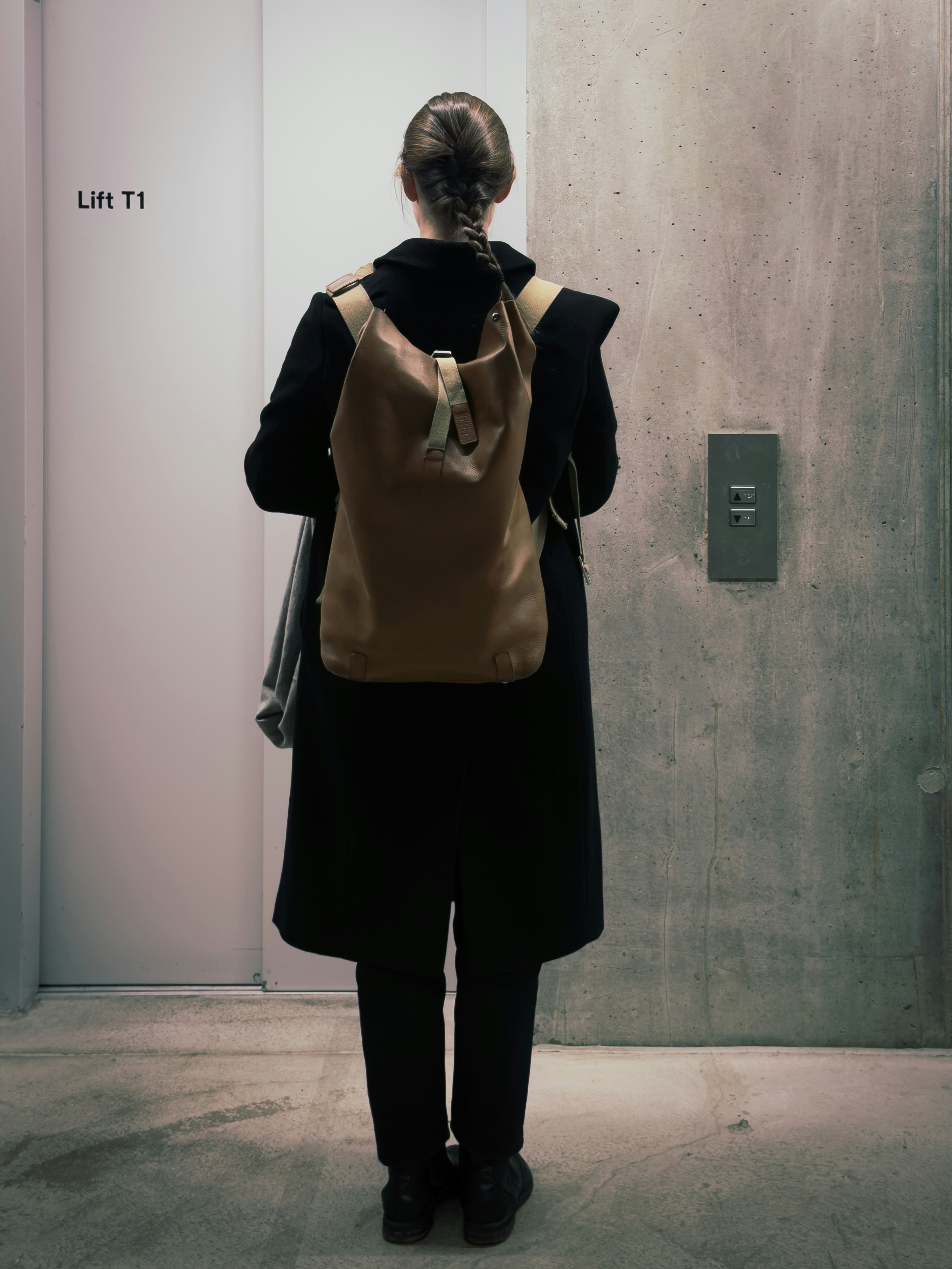 Back View of a Traveler: A Lone Student in a Concrete Corridor