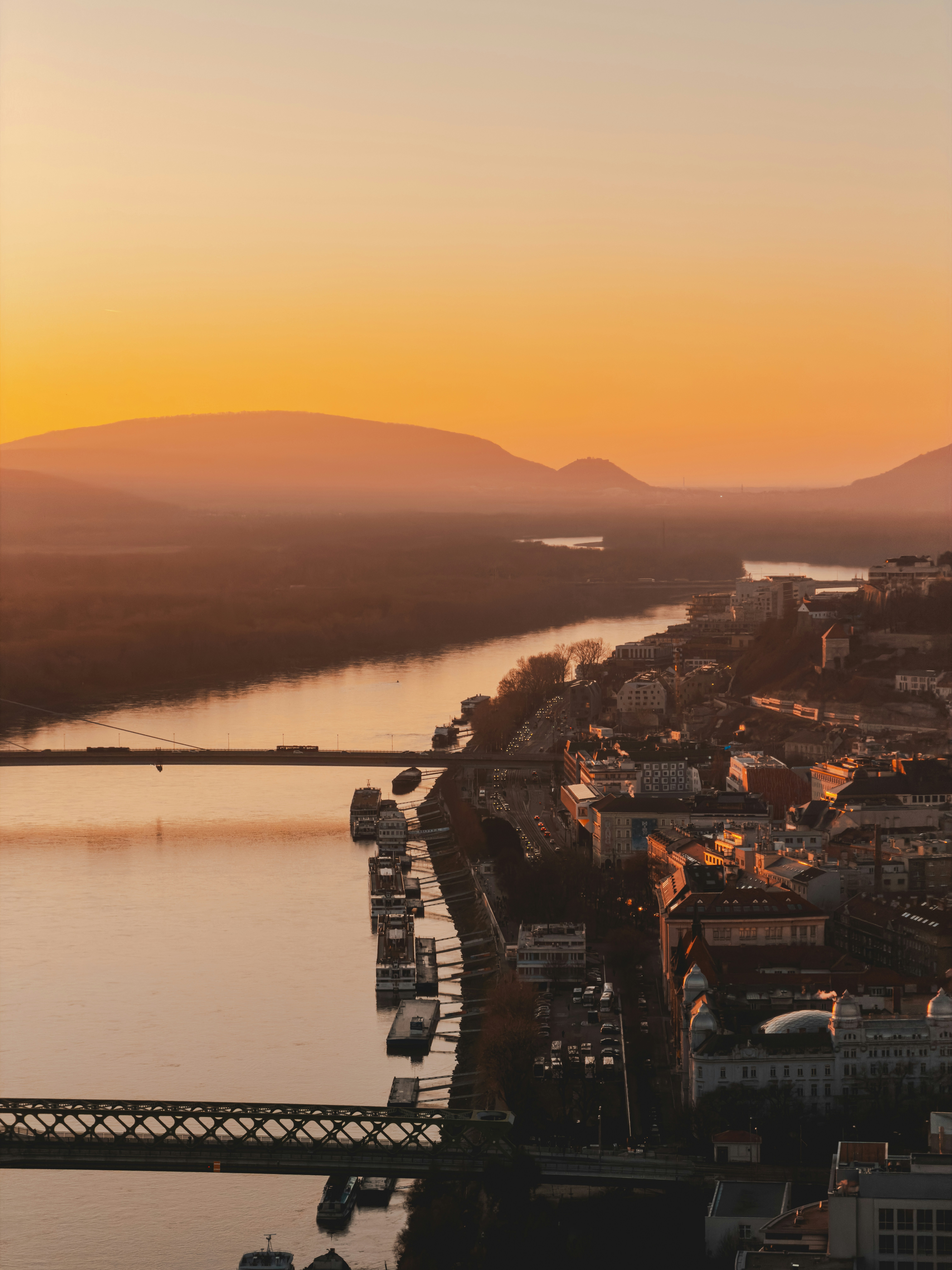 Golden Hour Over the Riverfront: A Sunset in the Hillside Town