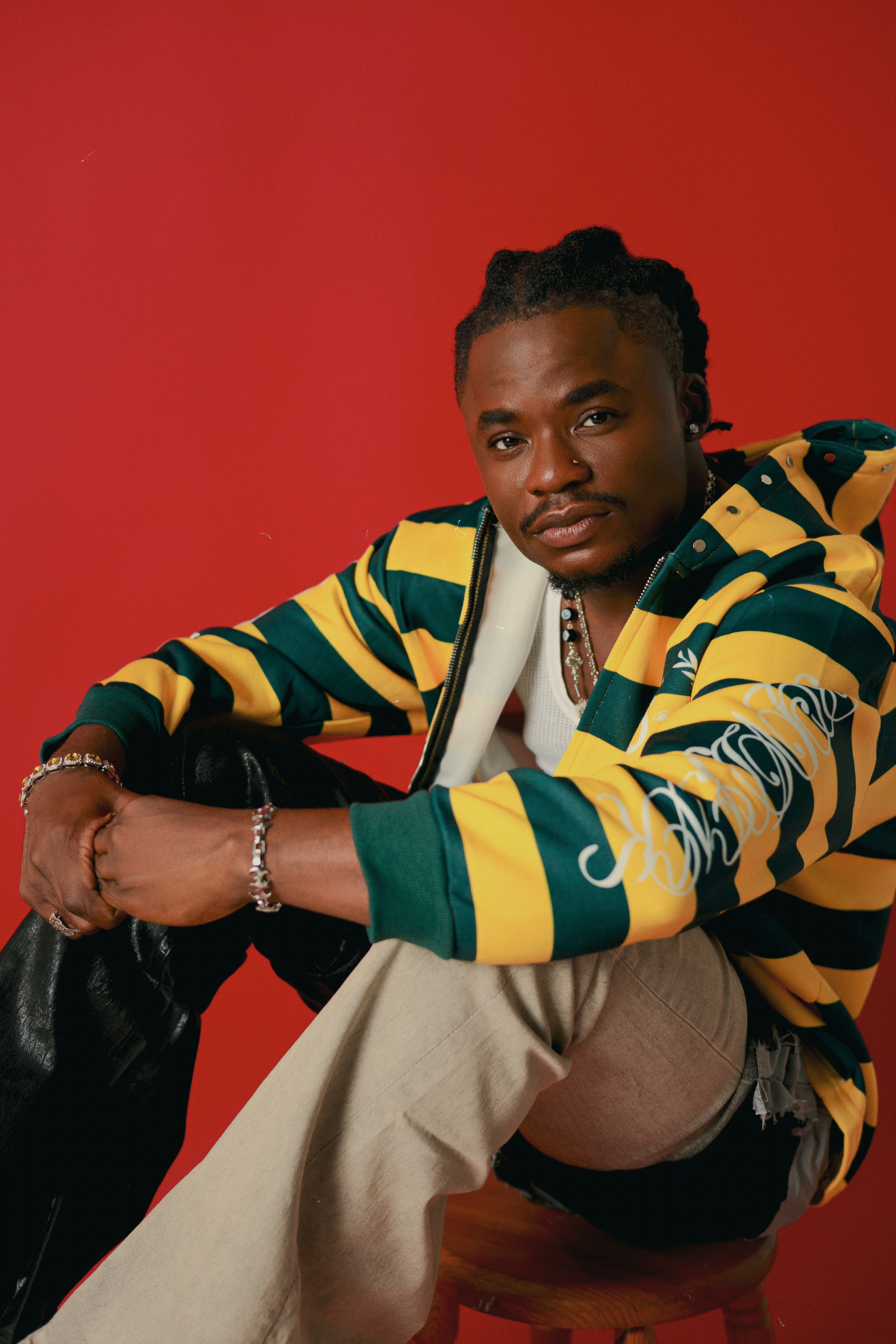 Bold Confident Portrait in Yellow-Green Stripes Against Scarlet Backdrop