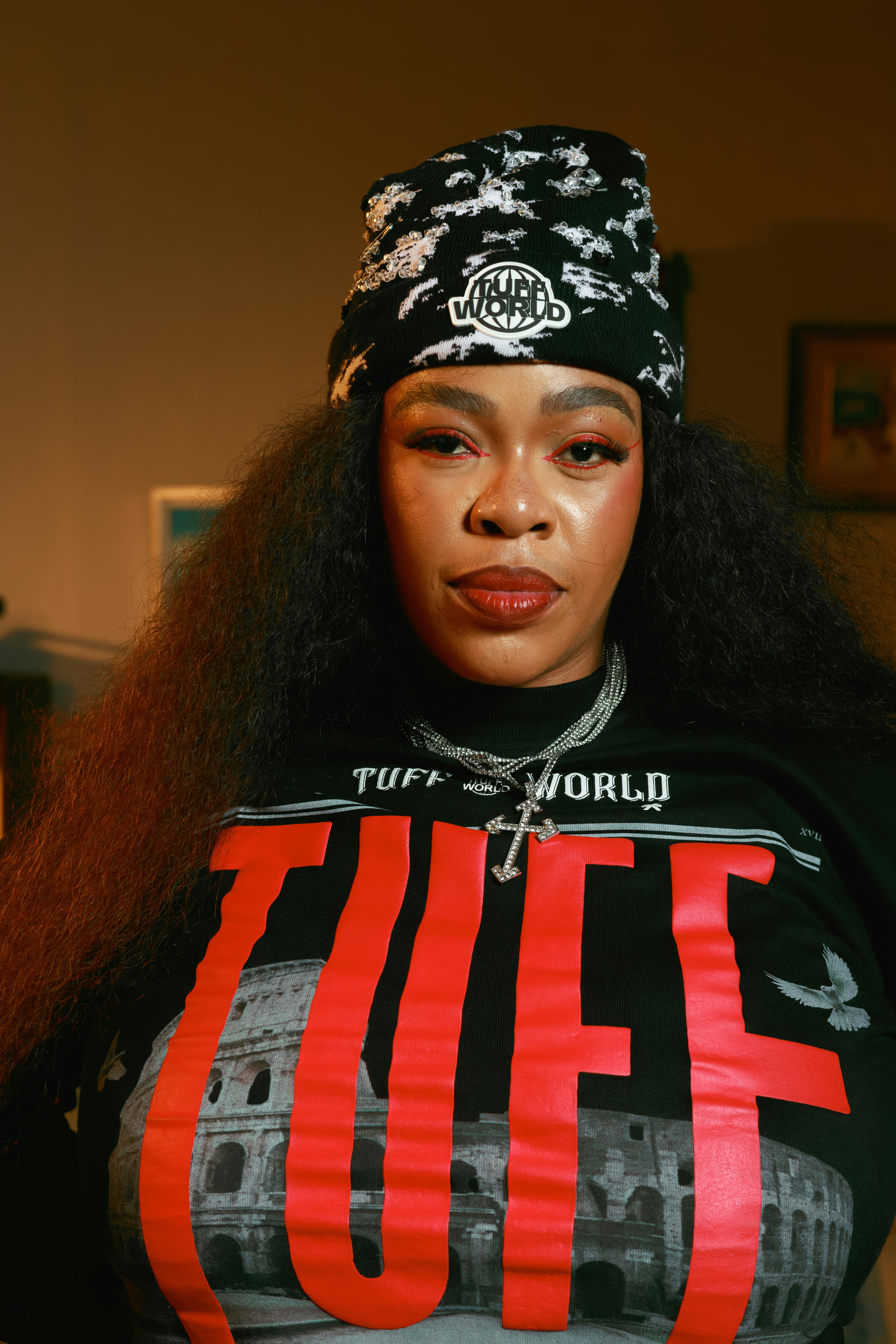 Bold portrait in warm living-room light with TUFF World tee
