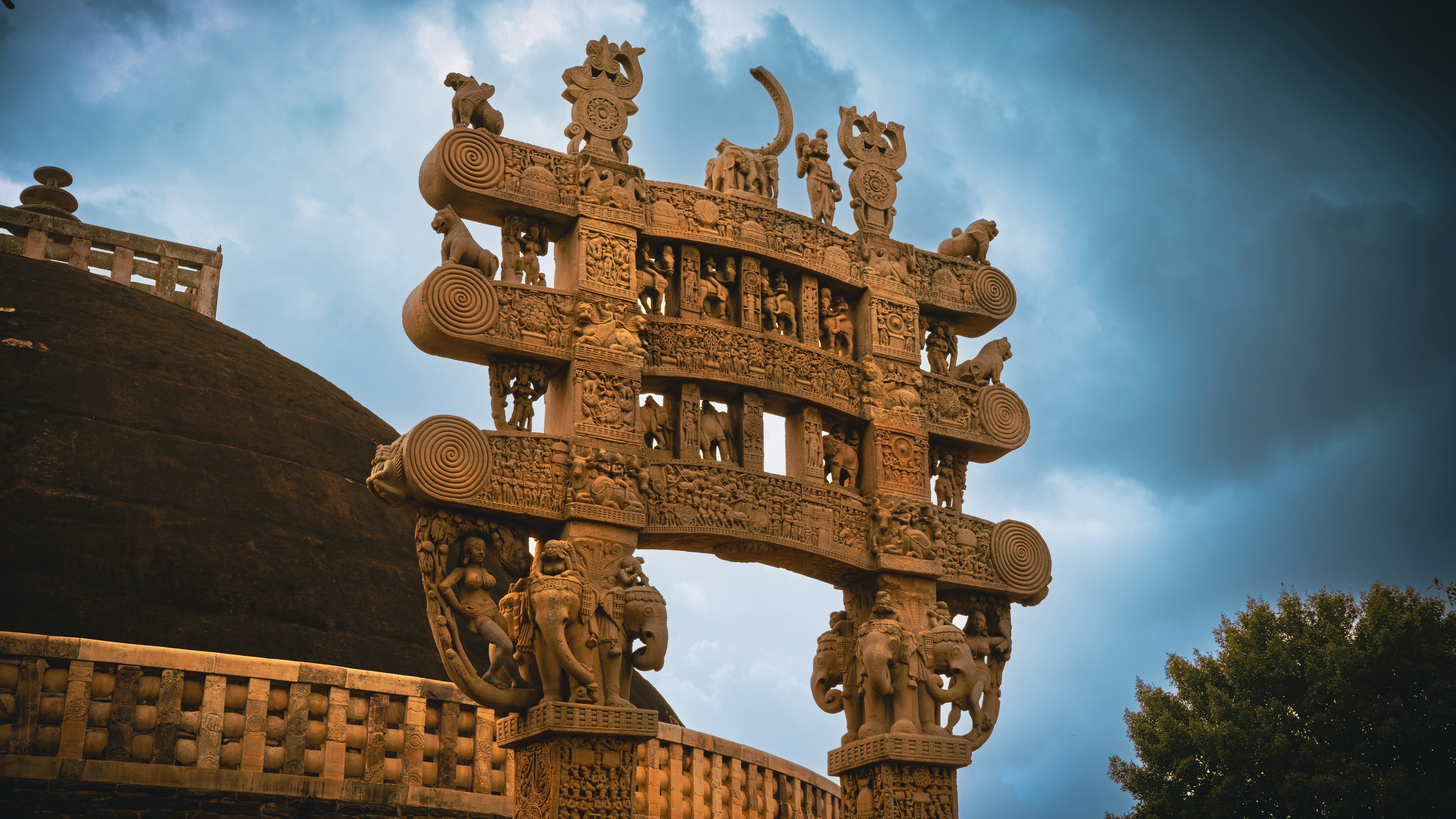 Carved ceremonial arch rising above a domed temple