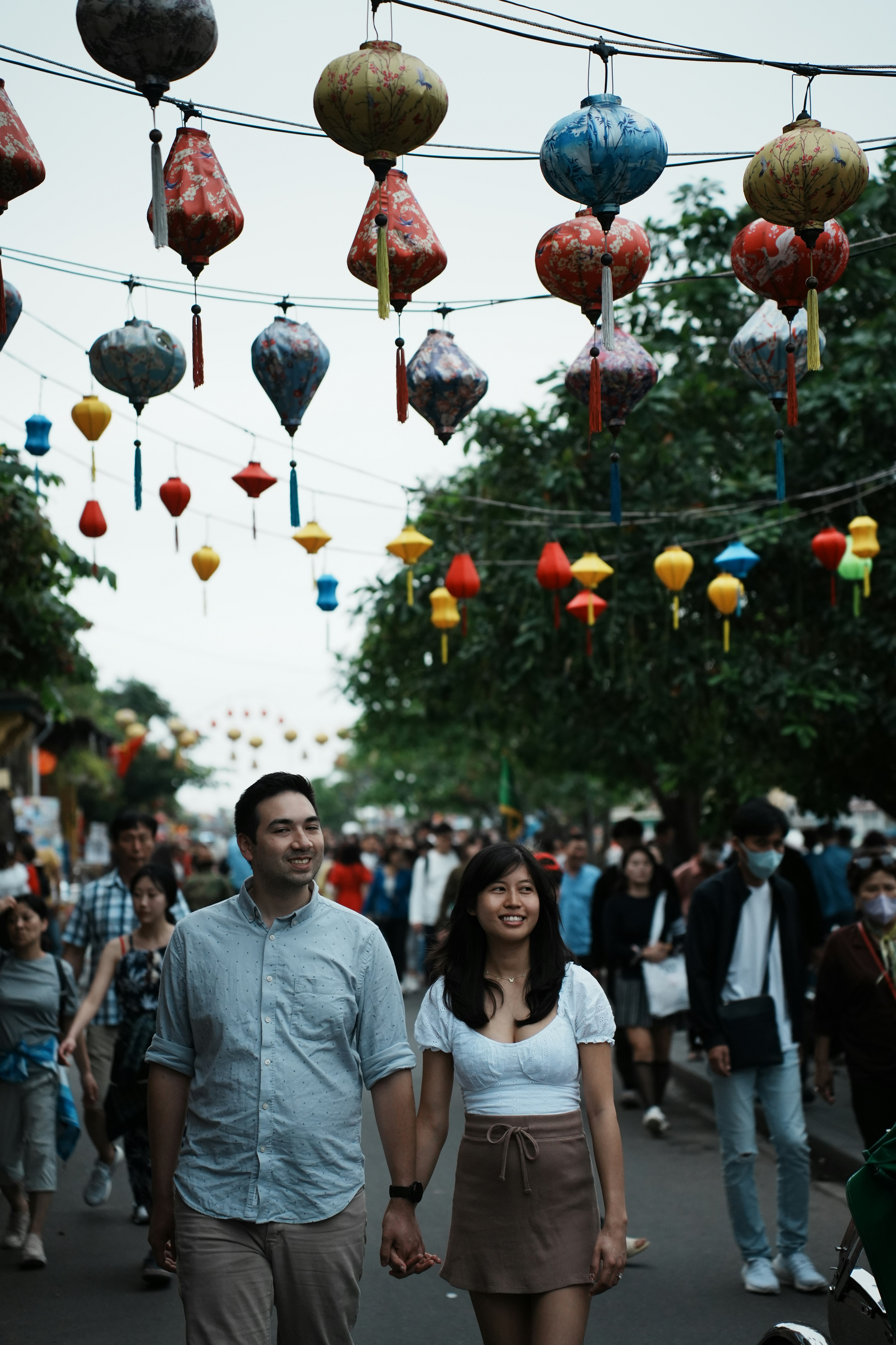 Holding Hands Amid Lanterns: A Street Festival Moment